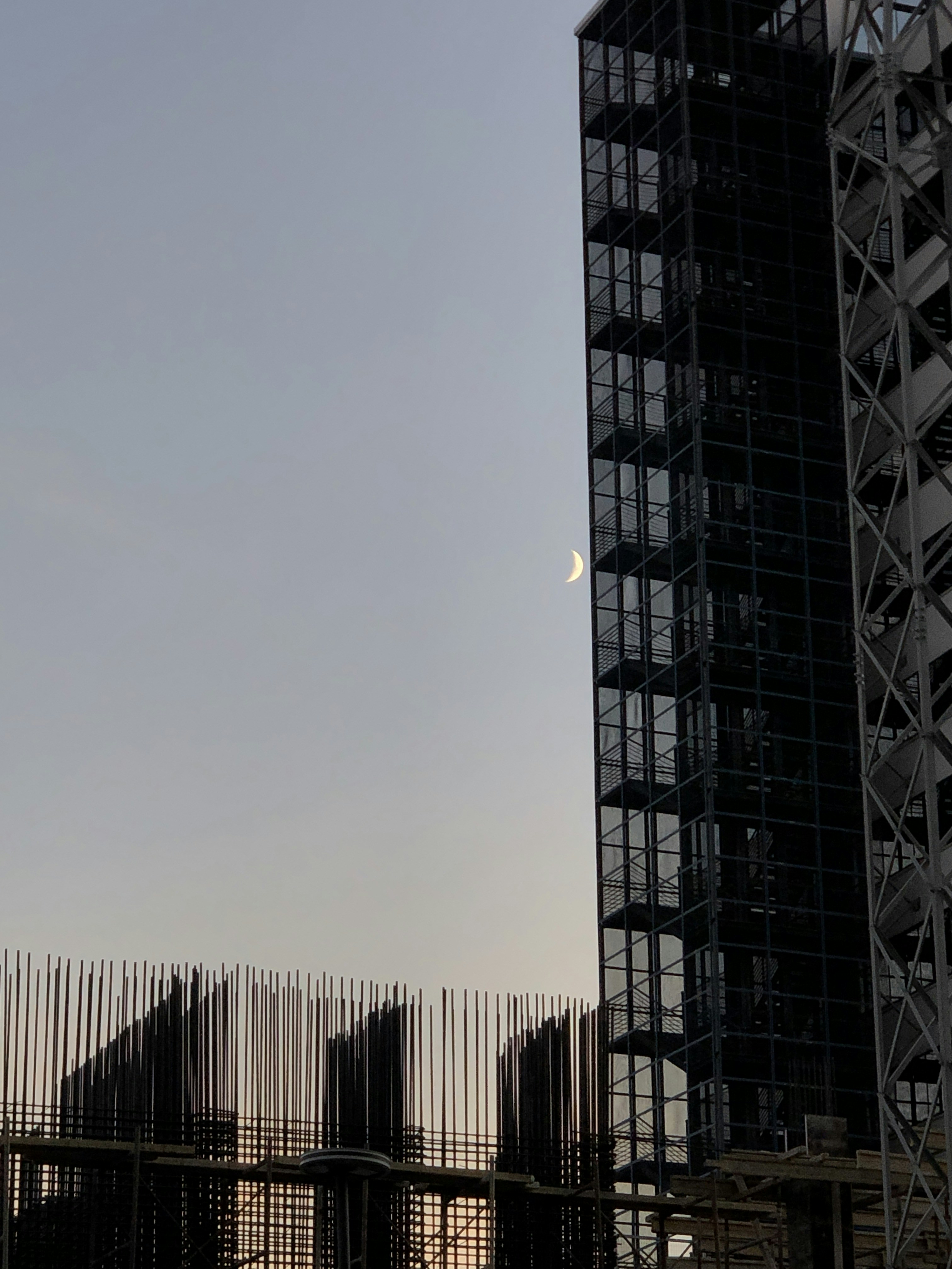 Moonlit Progress: Crescent Over a Constructing Skyline