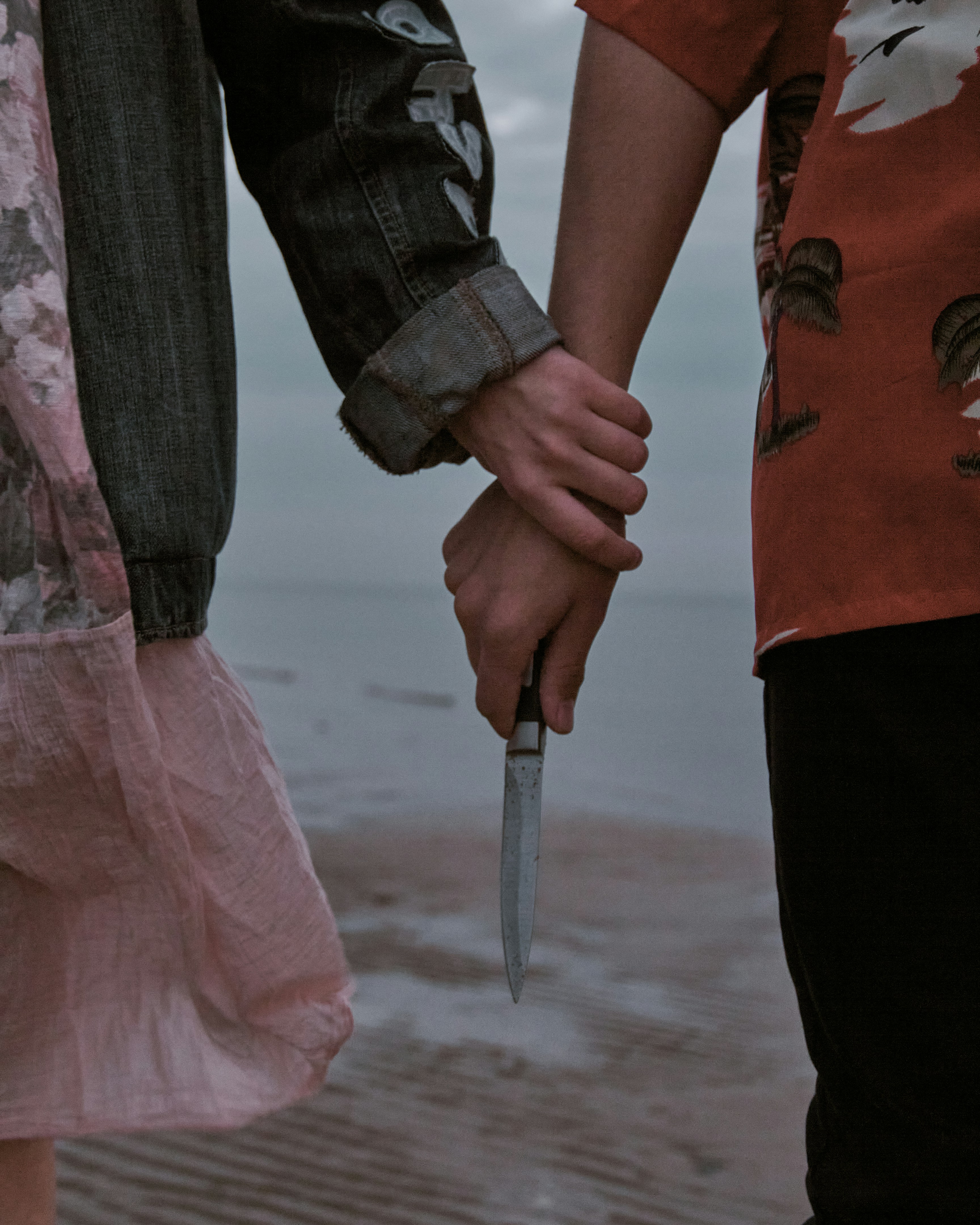 man in red and black crew neck t-shirt holding hands with woman in pink dress