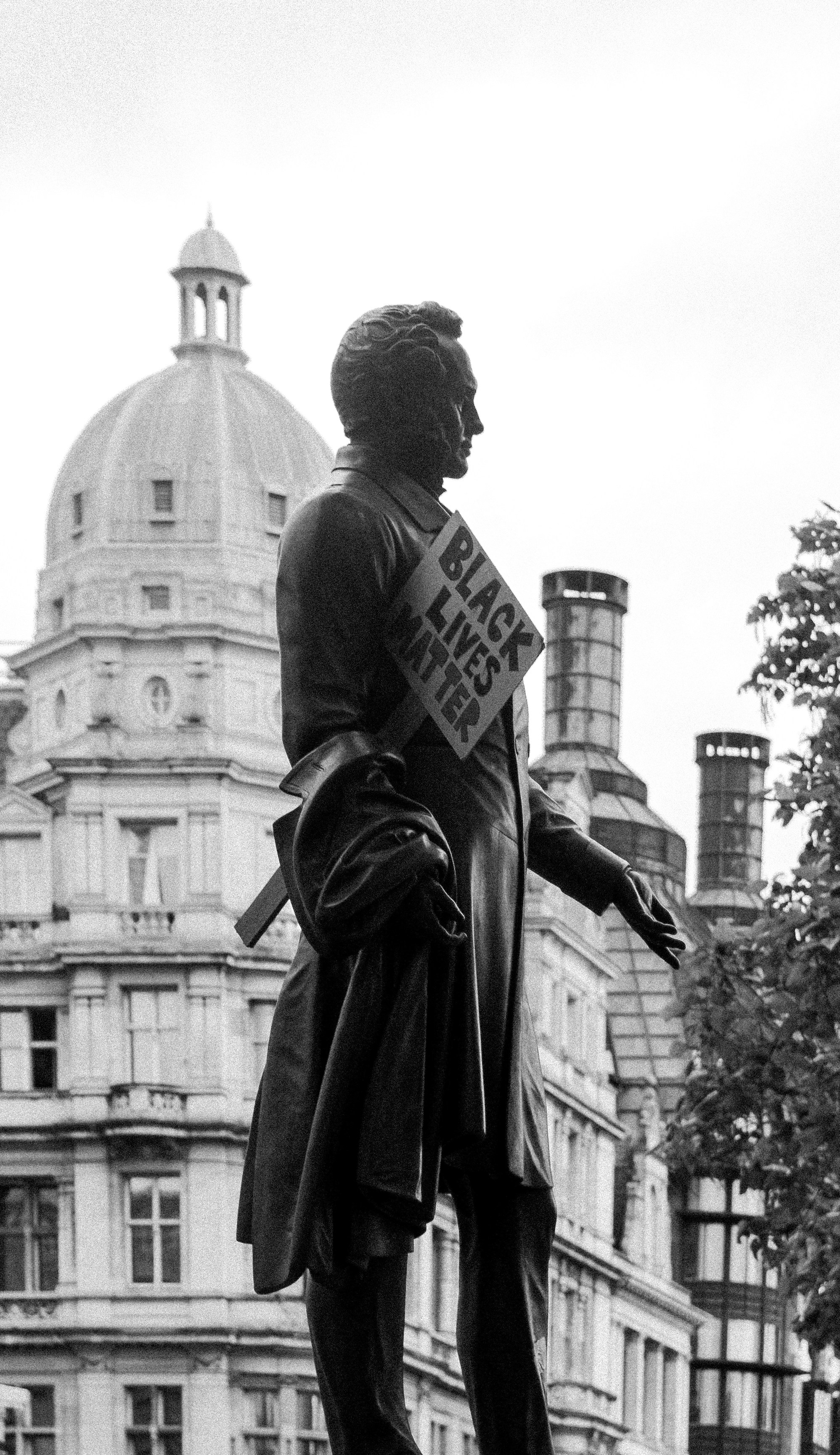 Statue with Protest Sign Over a Cityscape