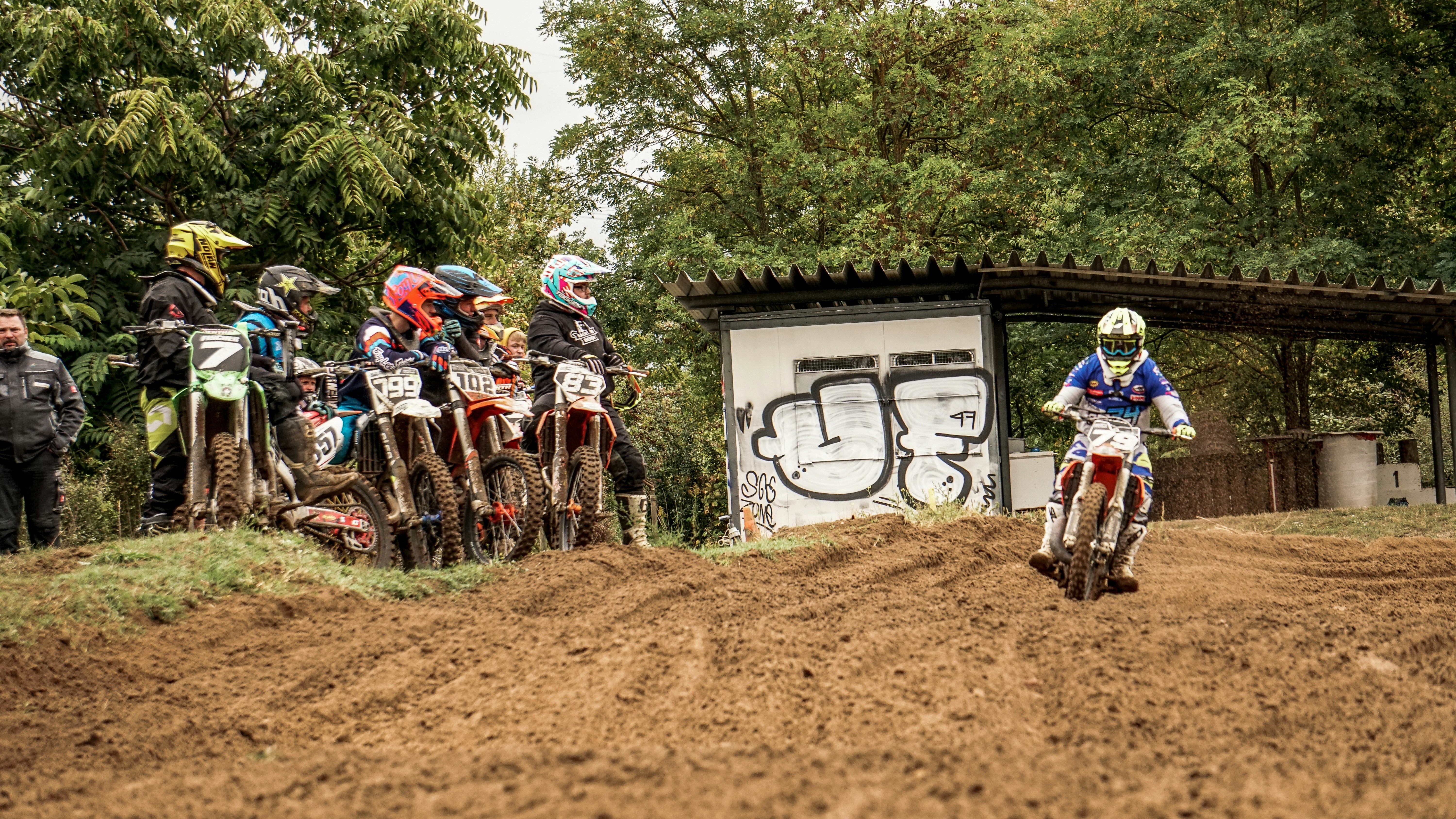 People riding motocross dirt bikes racing on dirt road during daytime ...