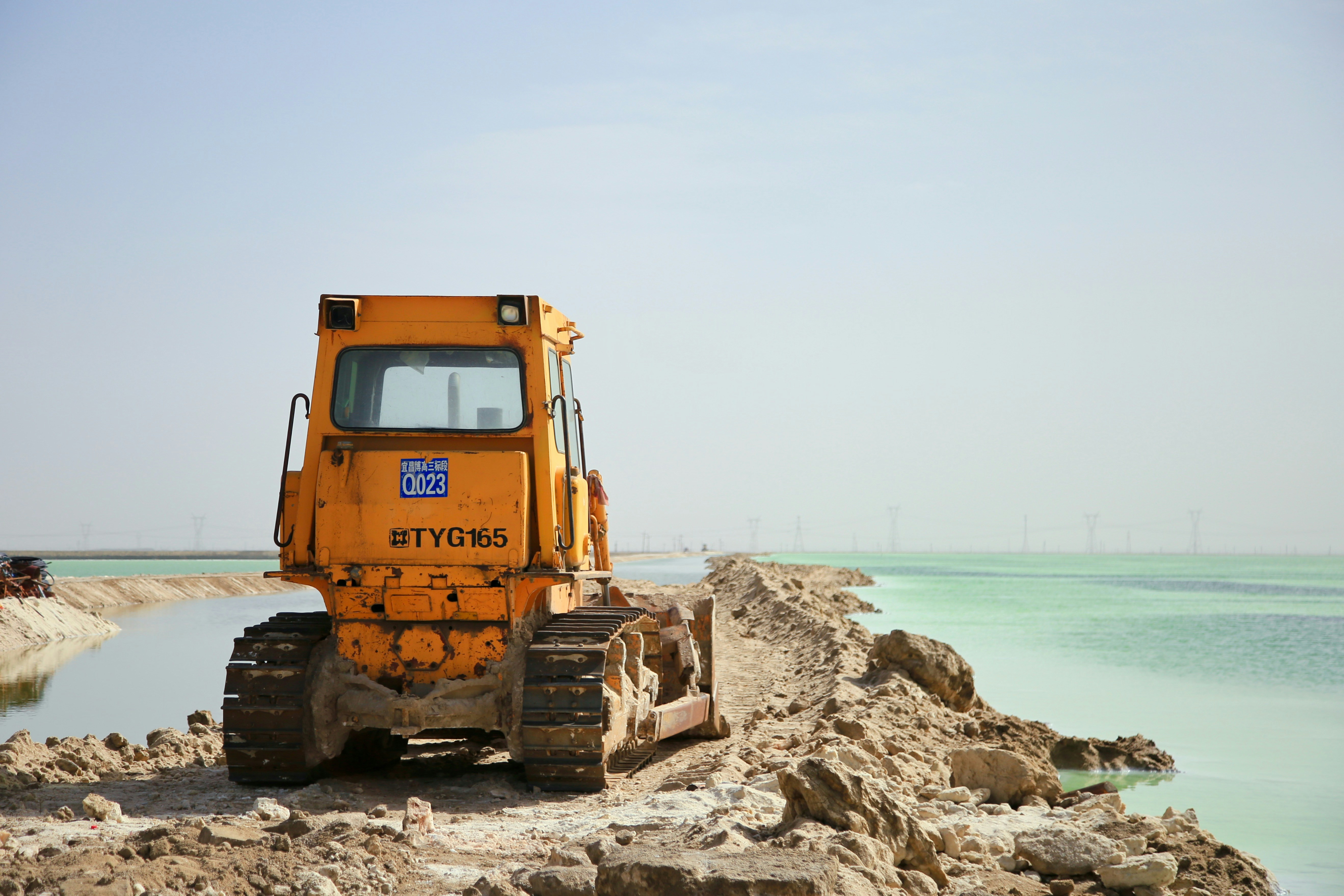 Yellow Excavator at the Edge of a Turquoise Salt Flat