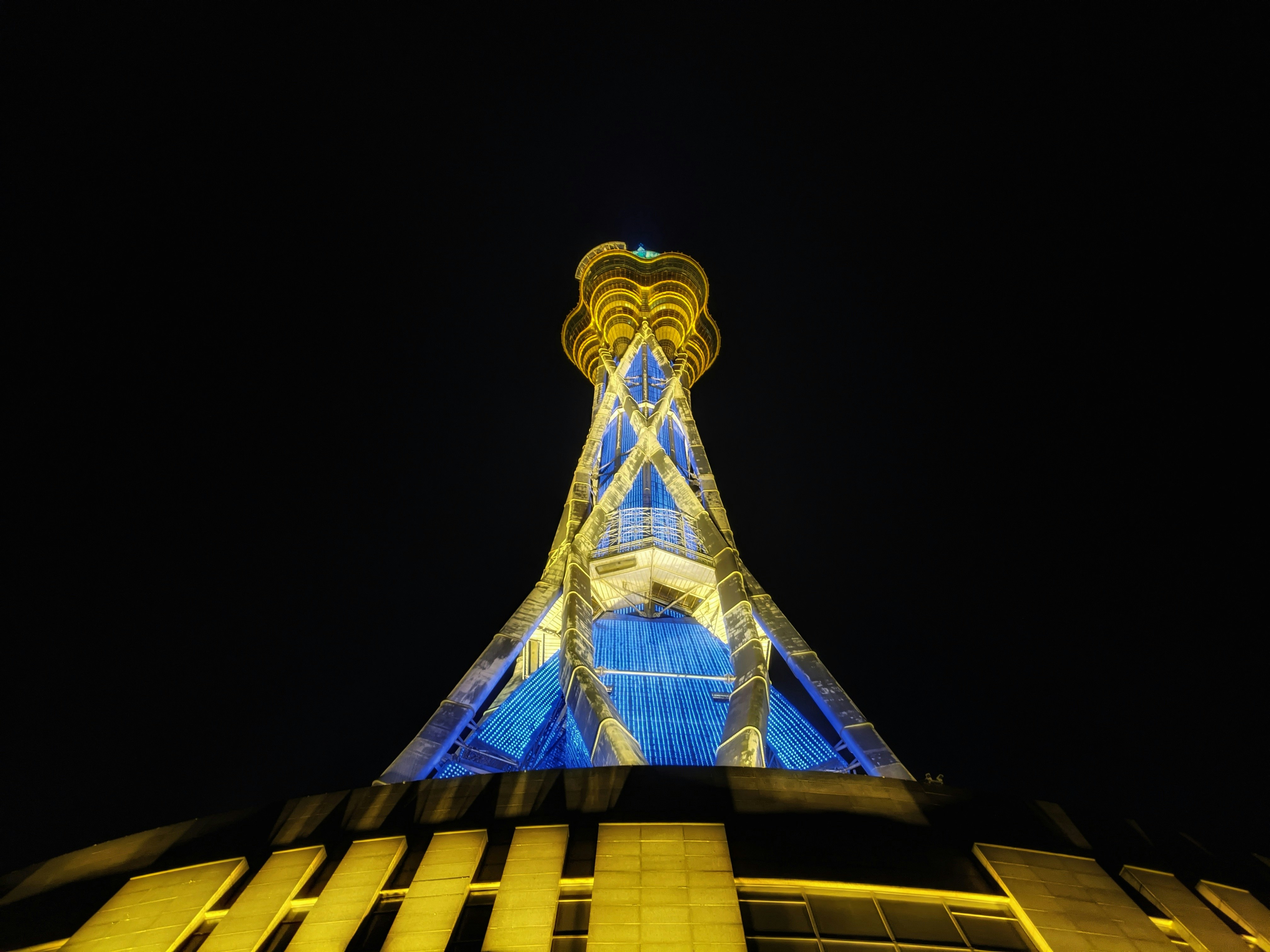 Neon Apex: Blue and Gold Tower Crowned by Night