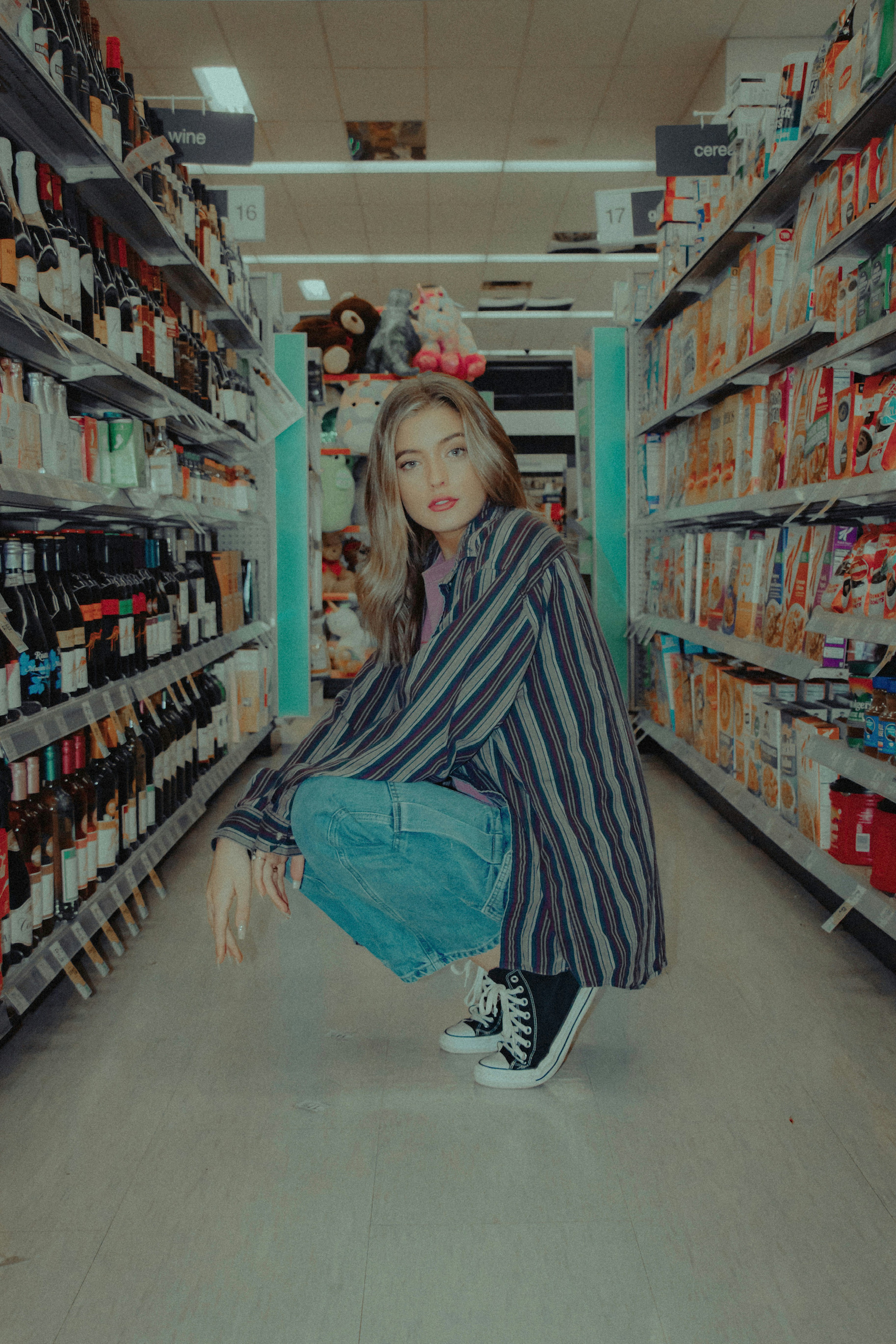 instagram: @liferondeau
model: @carissamitchell | woman in black and white striped long sleeve shirt and blue denim jeans sitting on gray