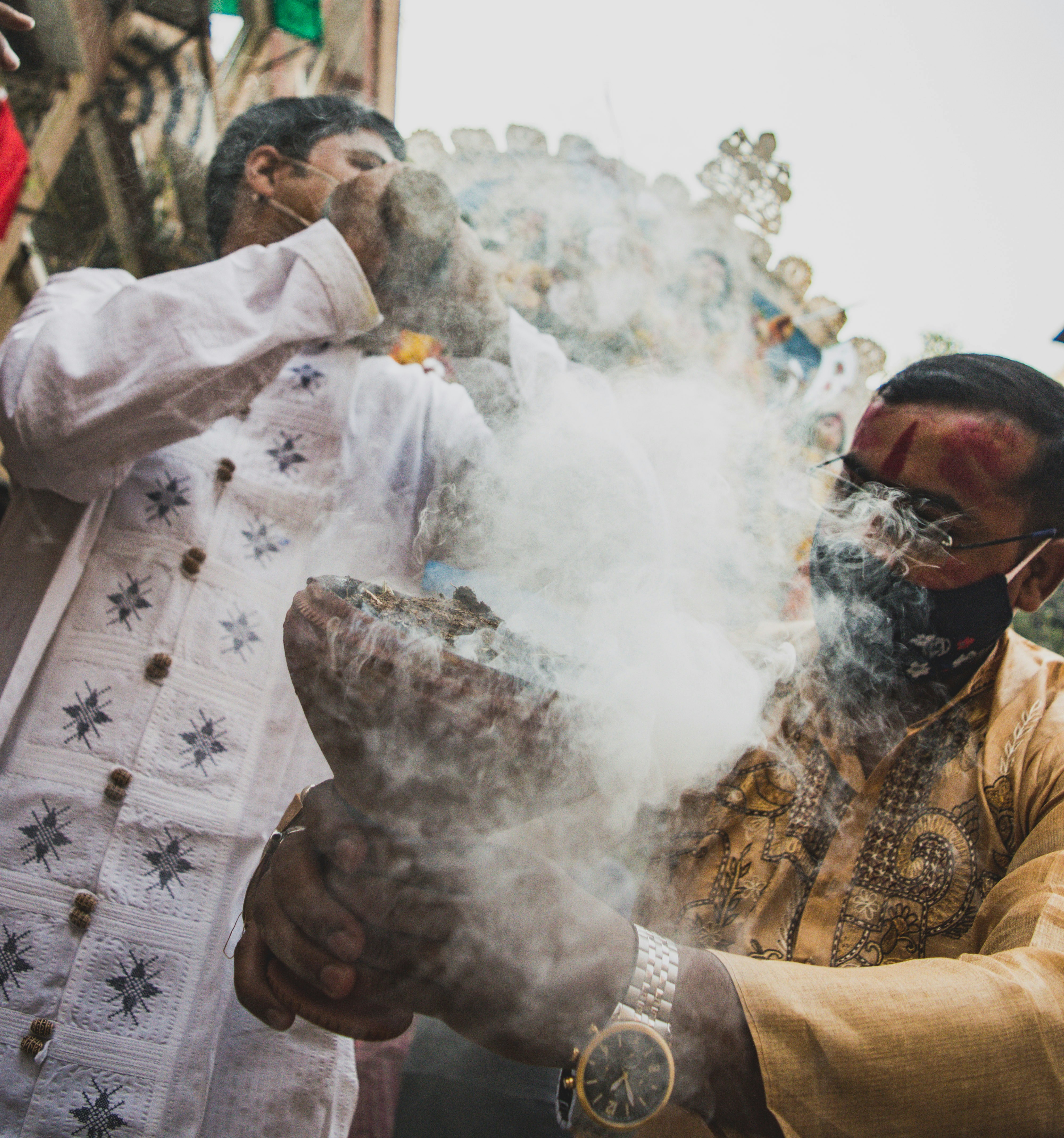 Smoke Between Hands: A Festival Moment Framed by Curious Onlookers