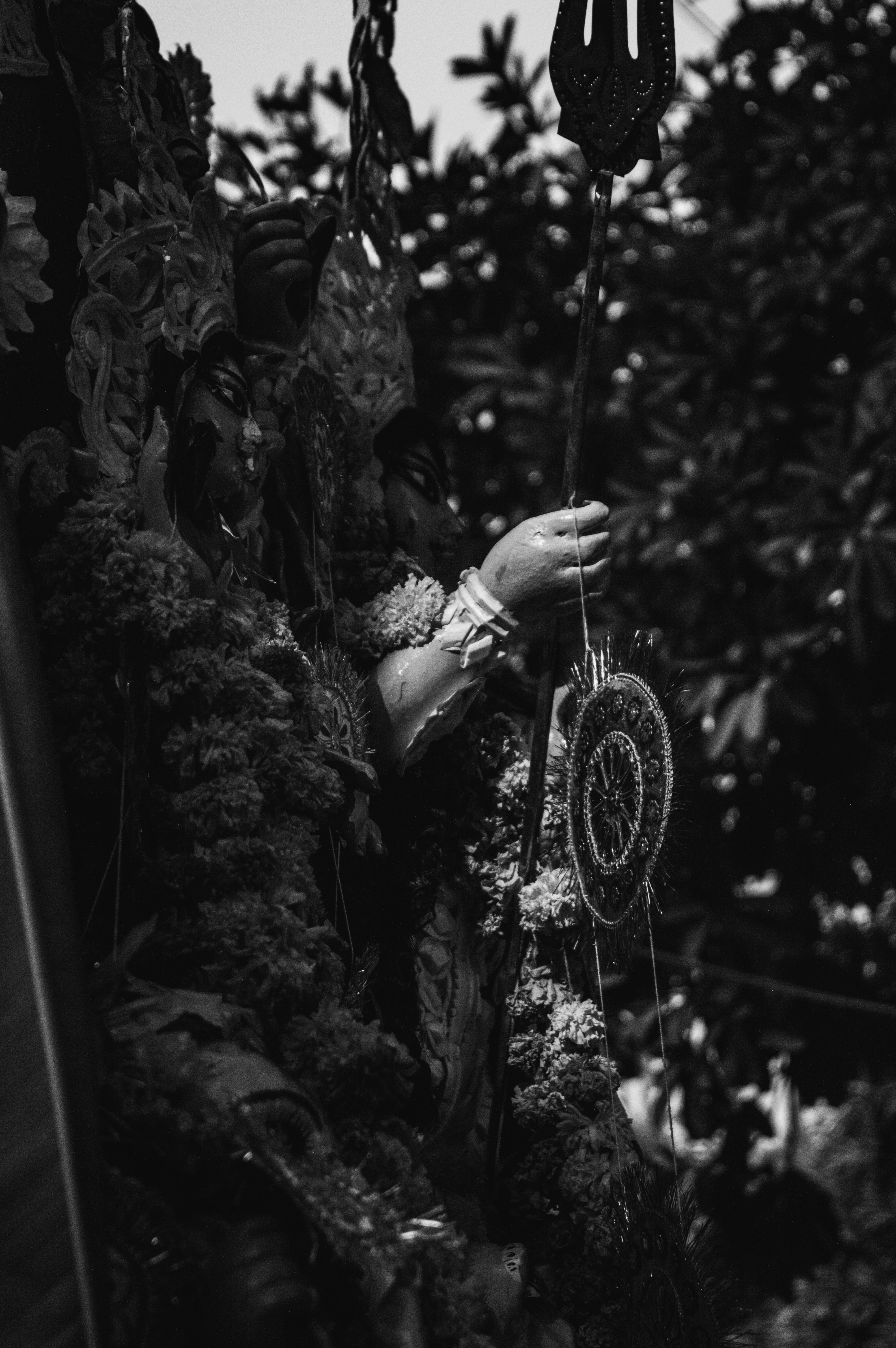 Monochrome Shrine: Hand, Garlands, and a Circular Pendant