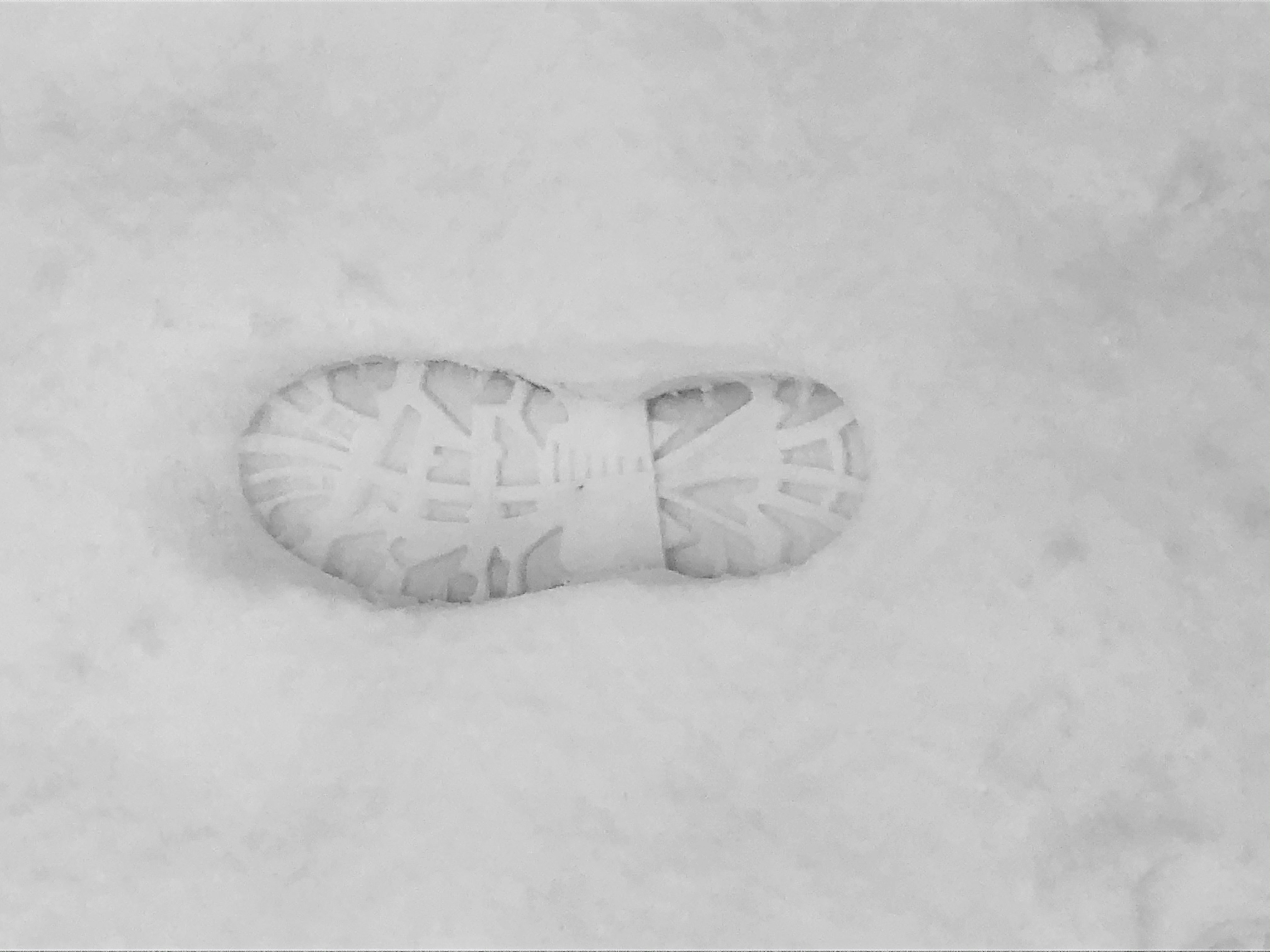 Solitary boot print in a quiet snowfield