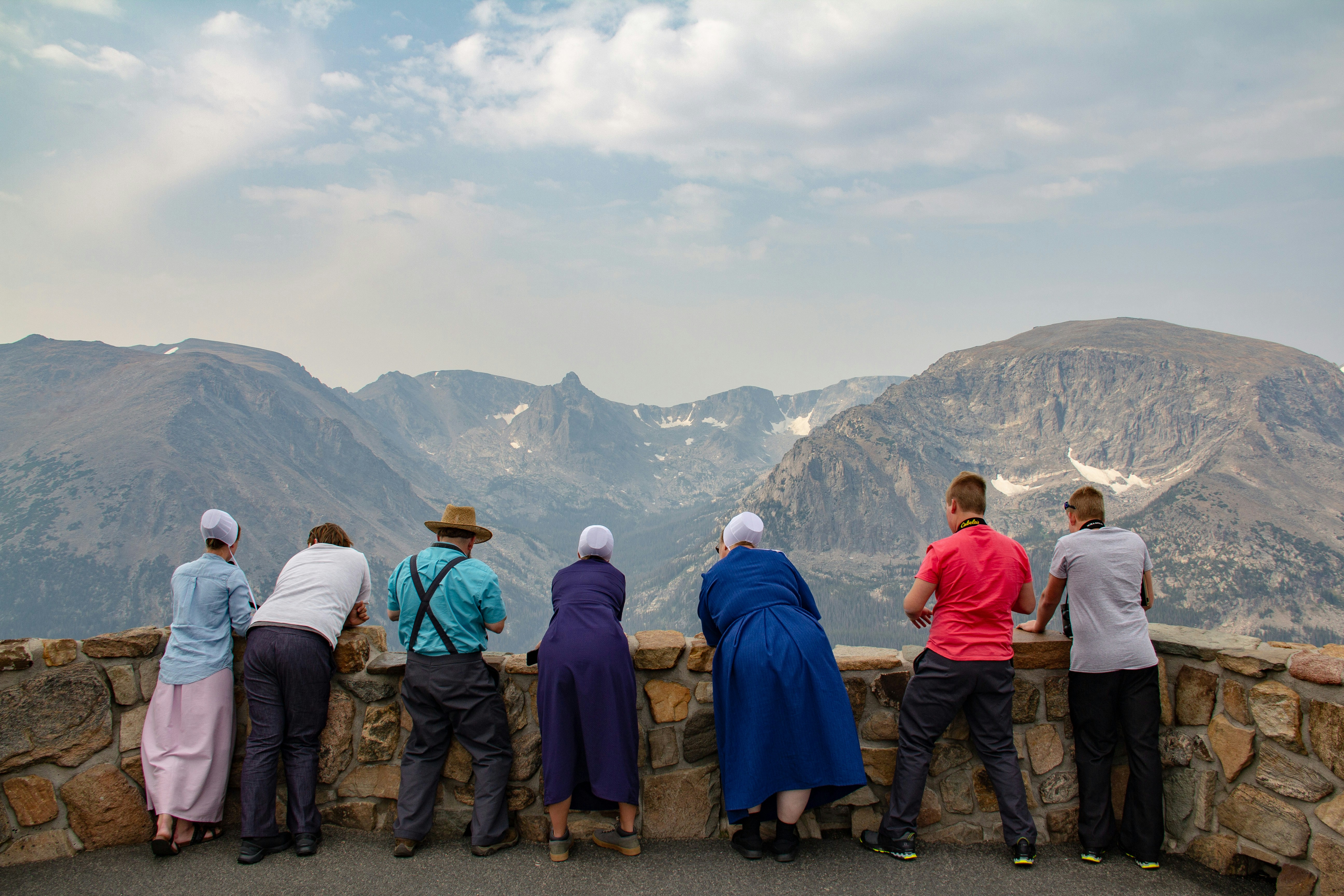 Stone-Wall Overlook: Tourists Embrace a Mountain Spine