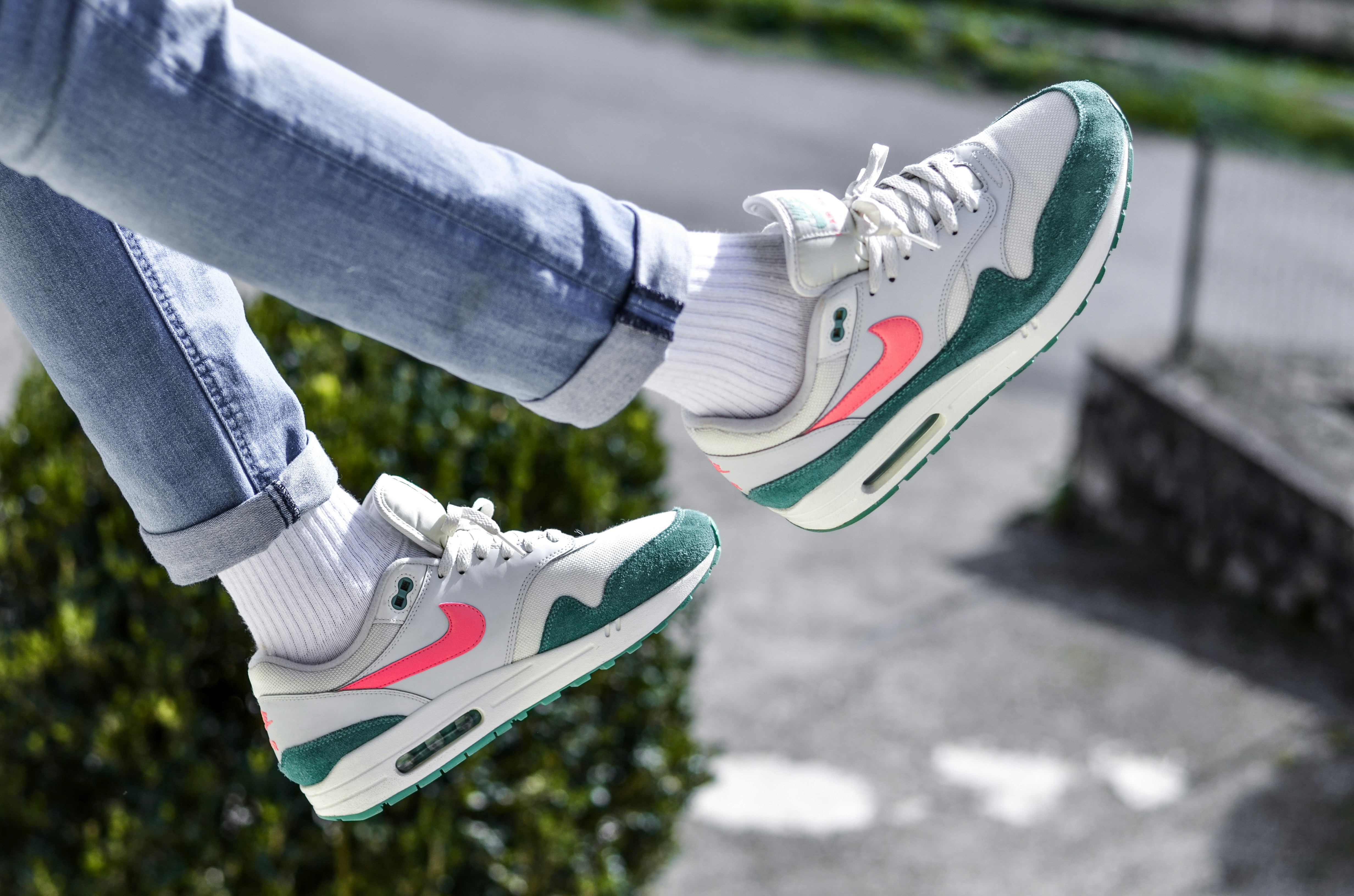 Pastel Sneakers in Midair: A Casual Leap Across Sunlit Stones