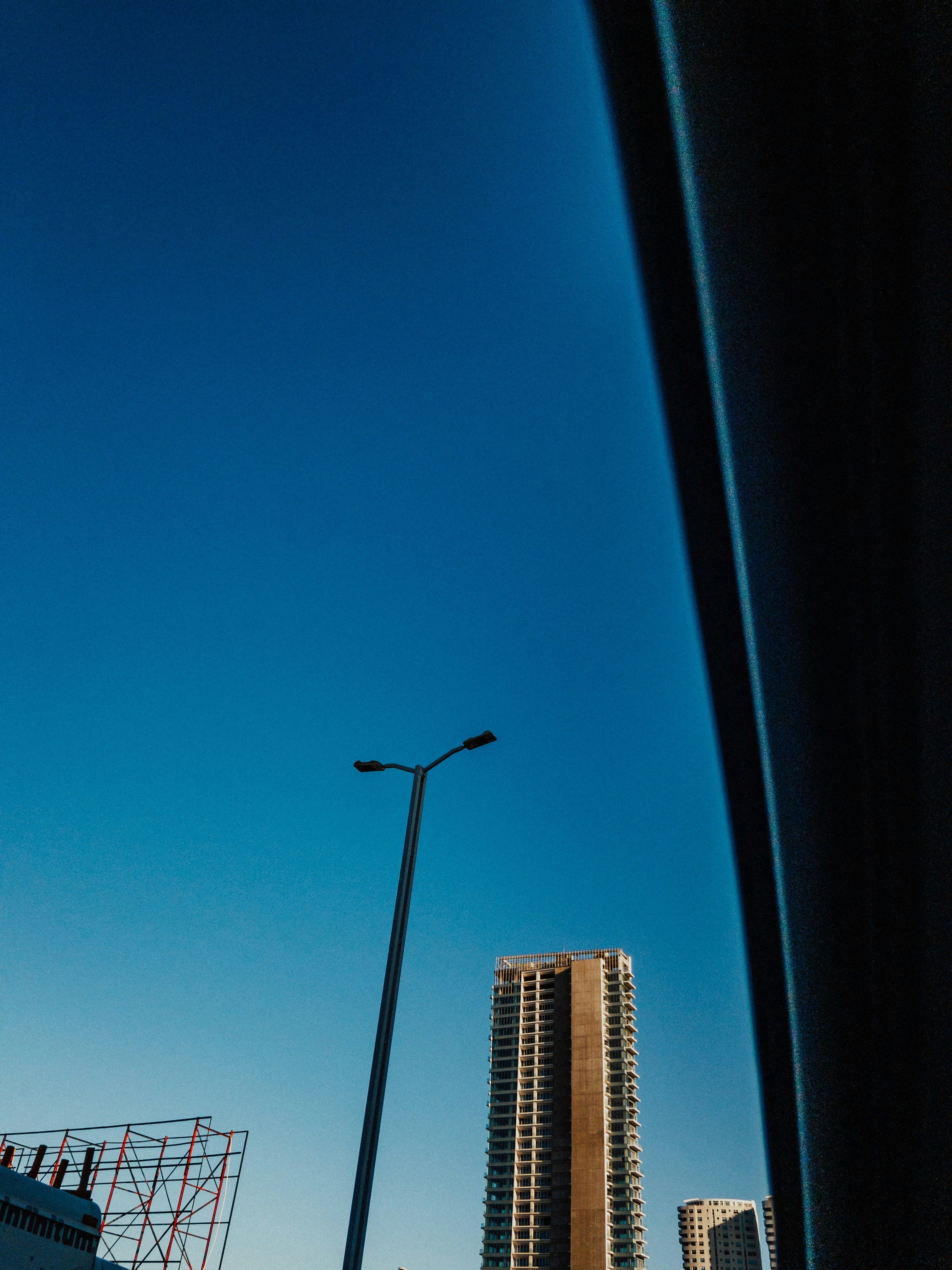 black street light near high rise building during daytime