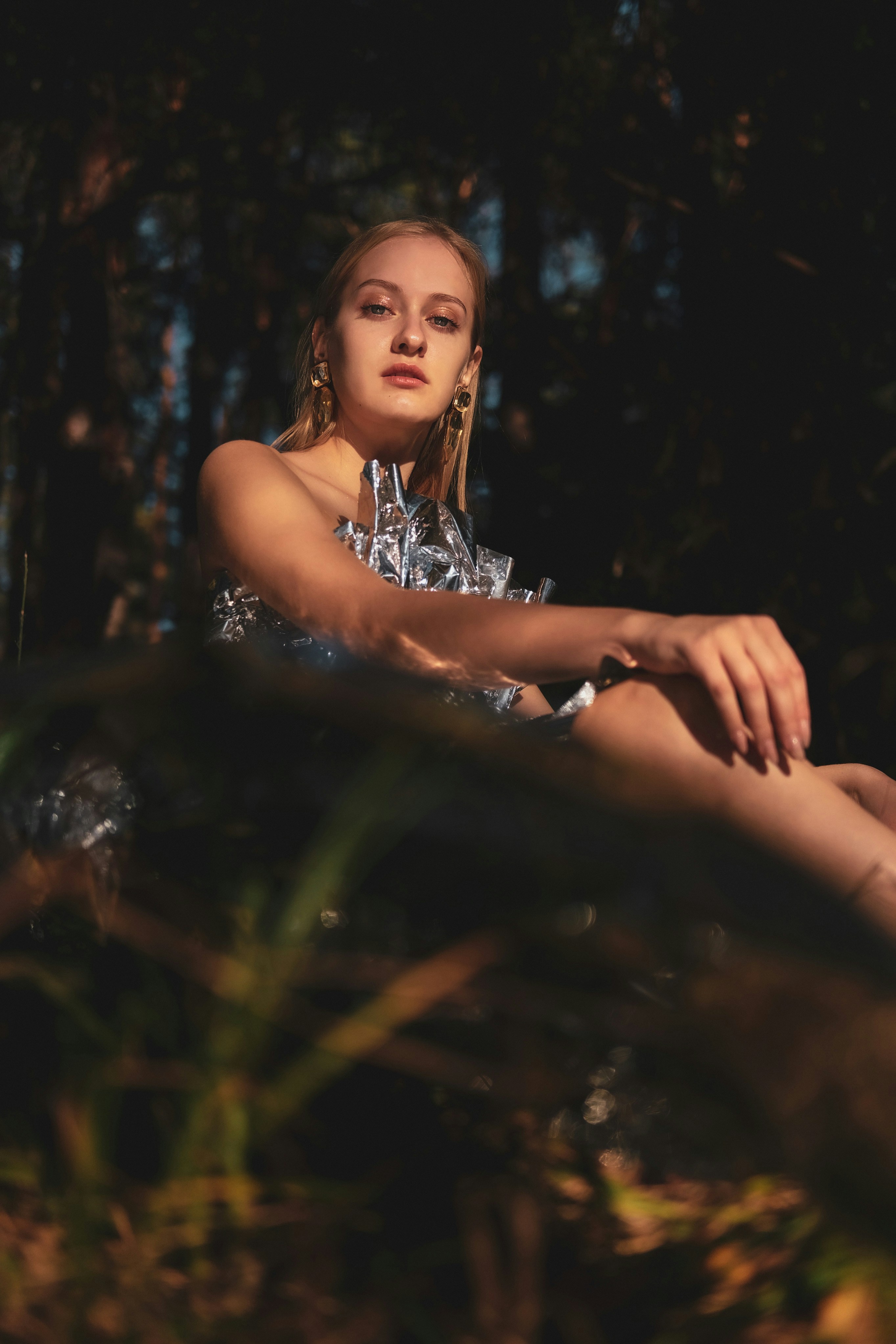 woman in white and black floral tank top sitting on green grass field