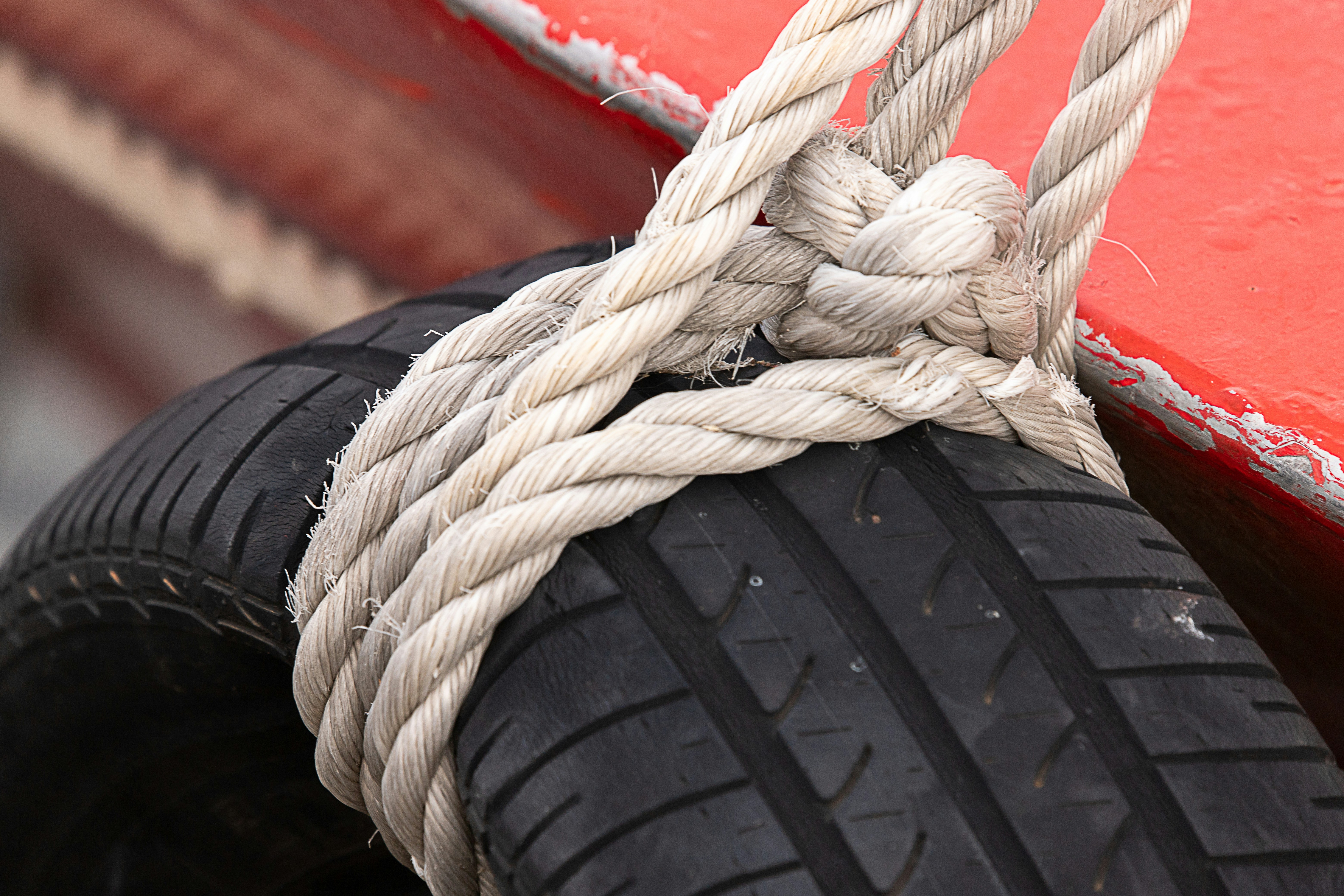 Knot and Tire: A Close-Up of Maritime Tension Under Red Hull