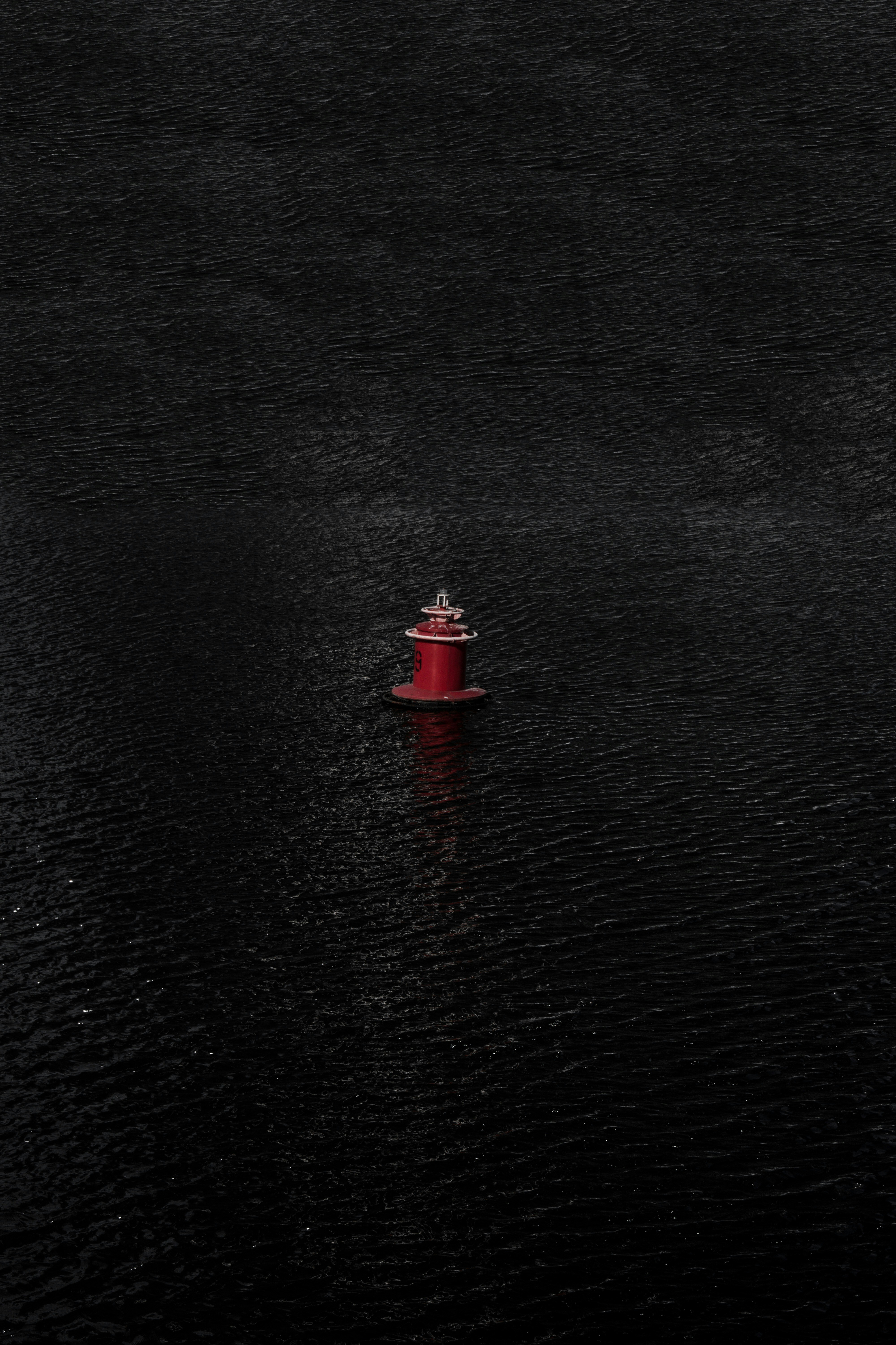Red and black lighthouse on body of water during daytime photo – Free ...