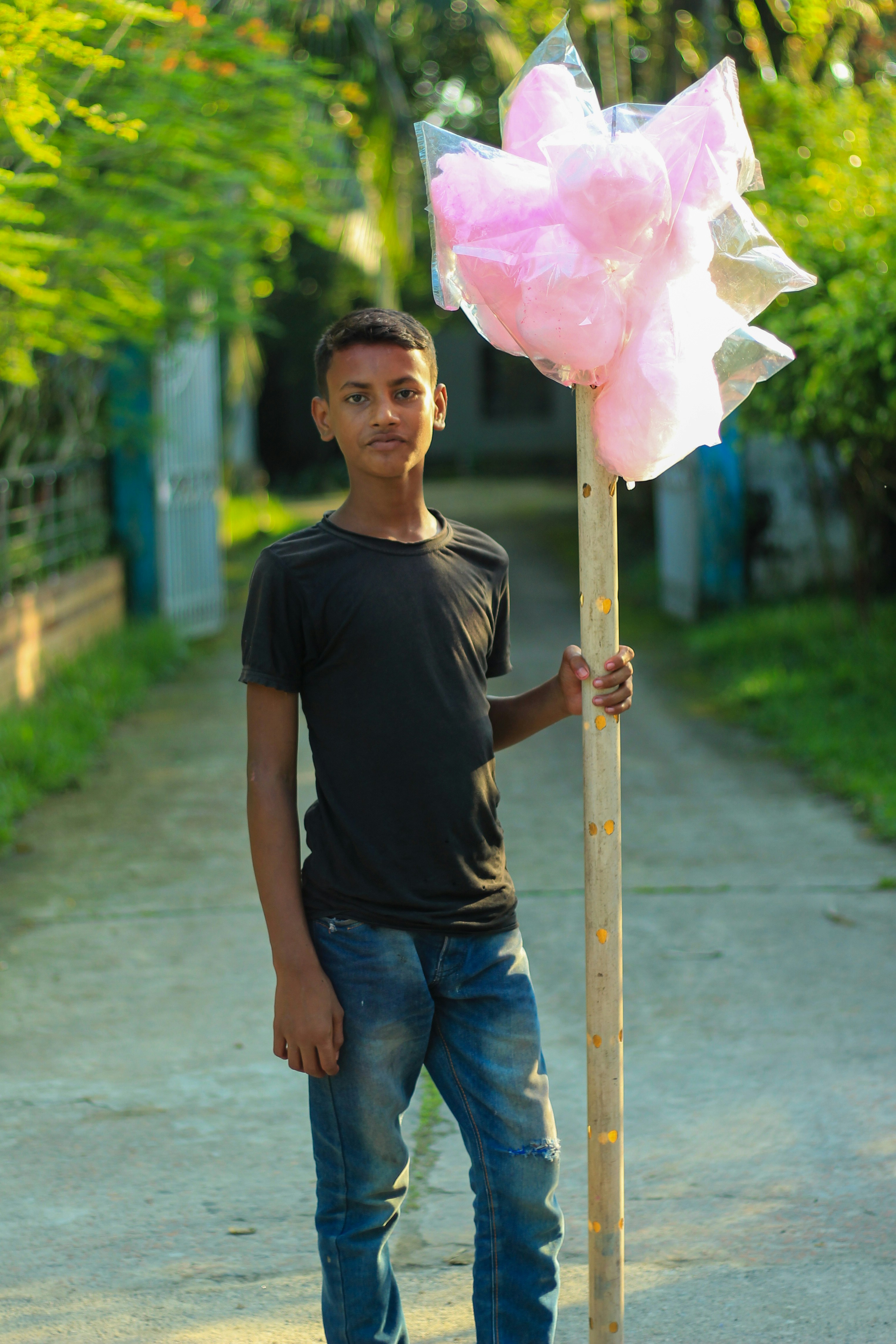 man in black crew neck t-shirt holding pink umbrella