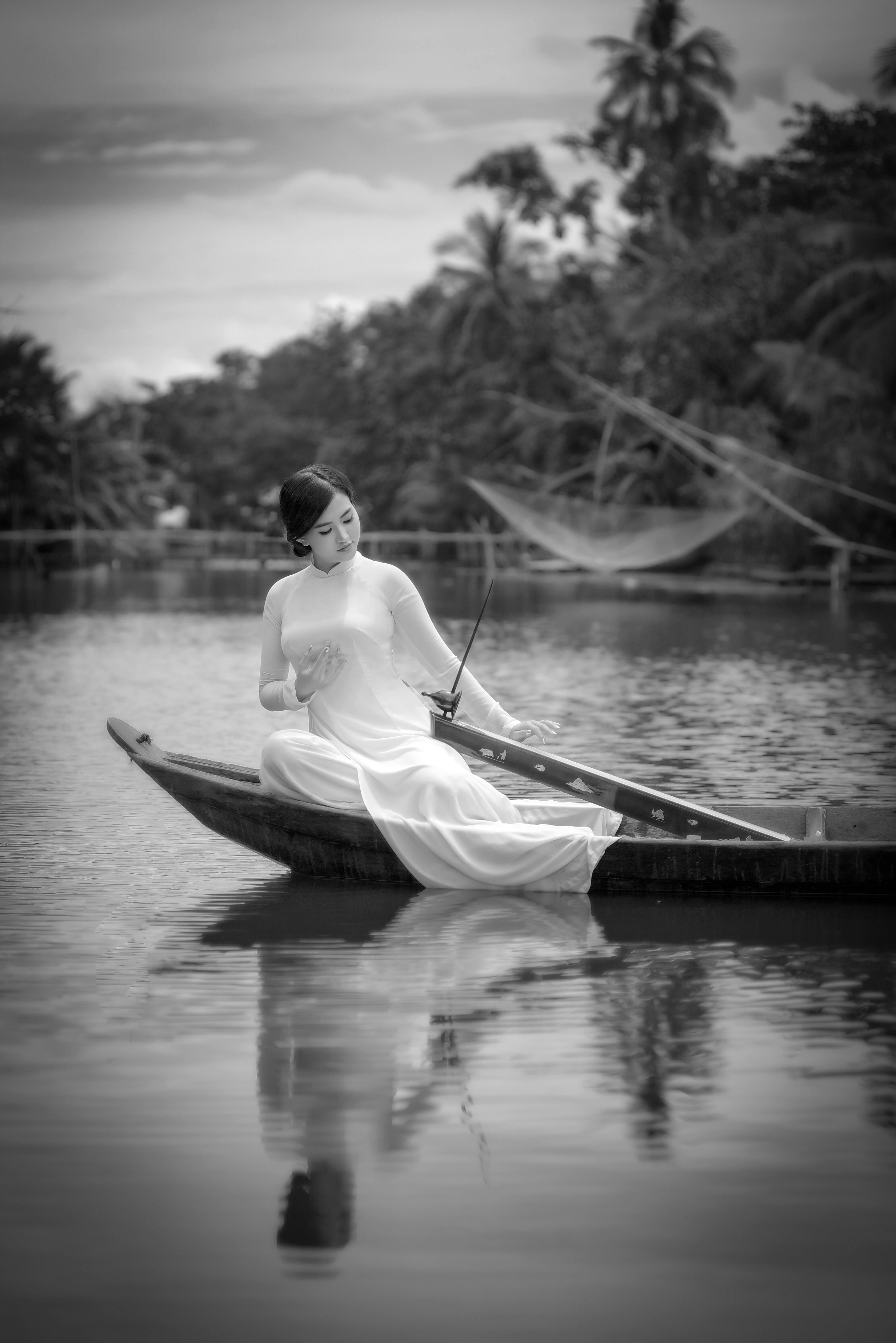 Silken Stillness: A Woman in a Canoe Beneath Quiet Skies