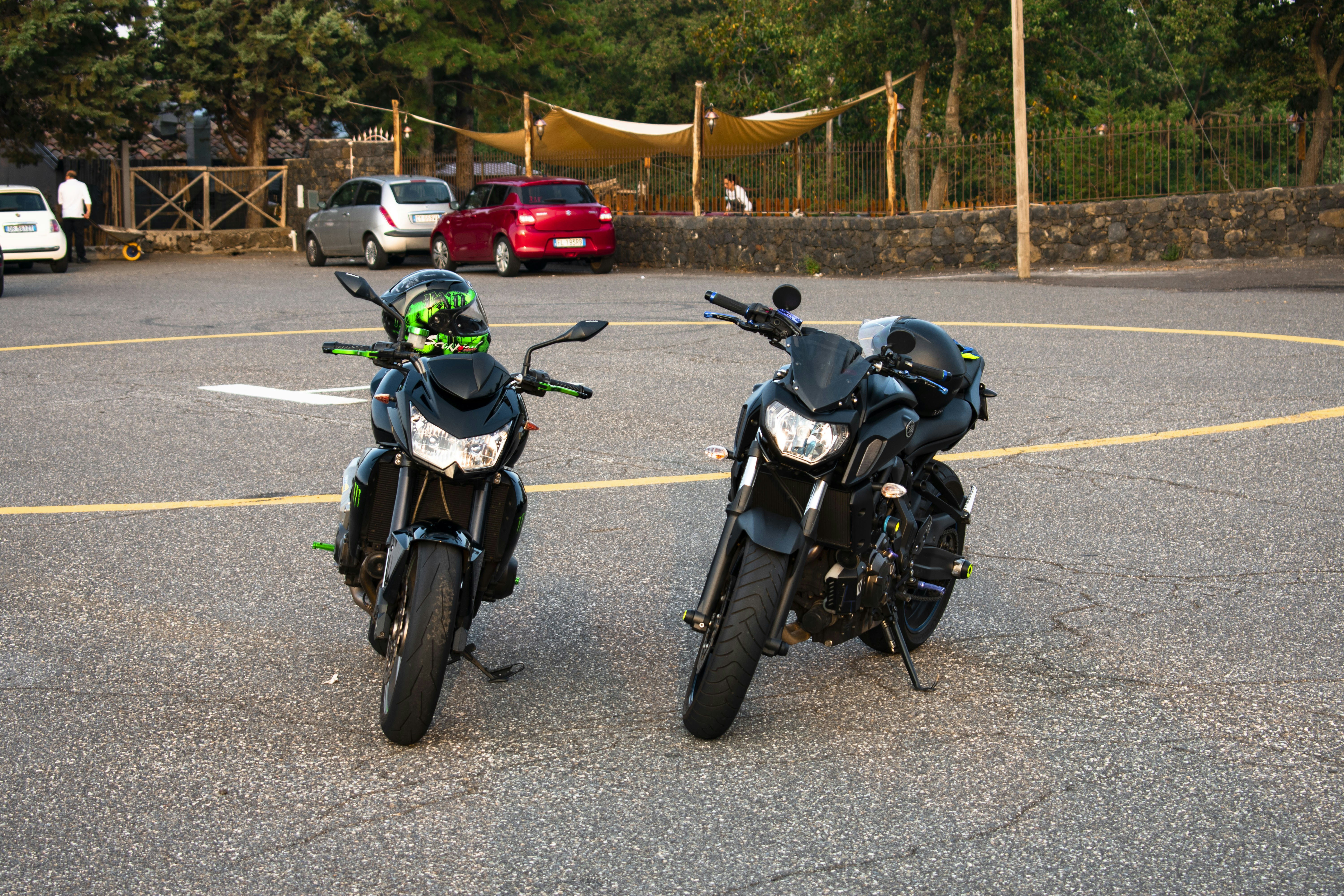 昼間に灰色のアスファルト道路に駐車した黒と緑のオートバイの写真 – Unsplashのオートバイの無料画像