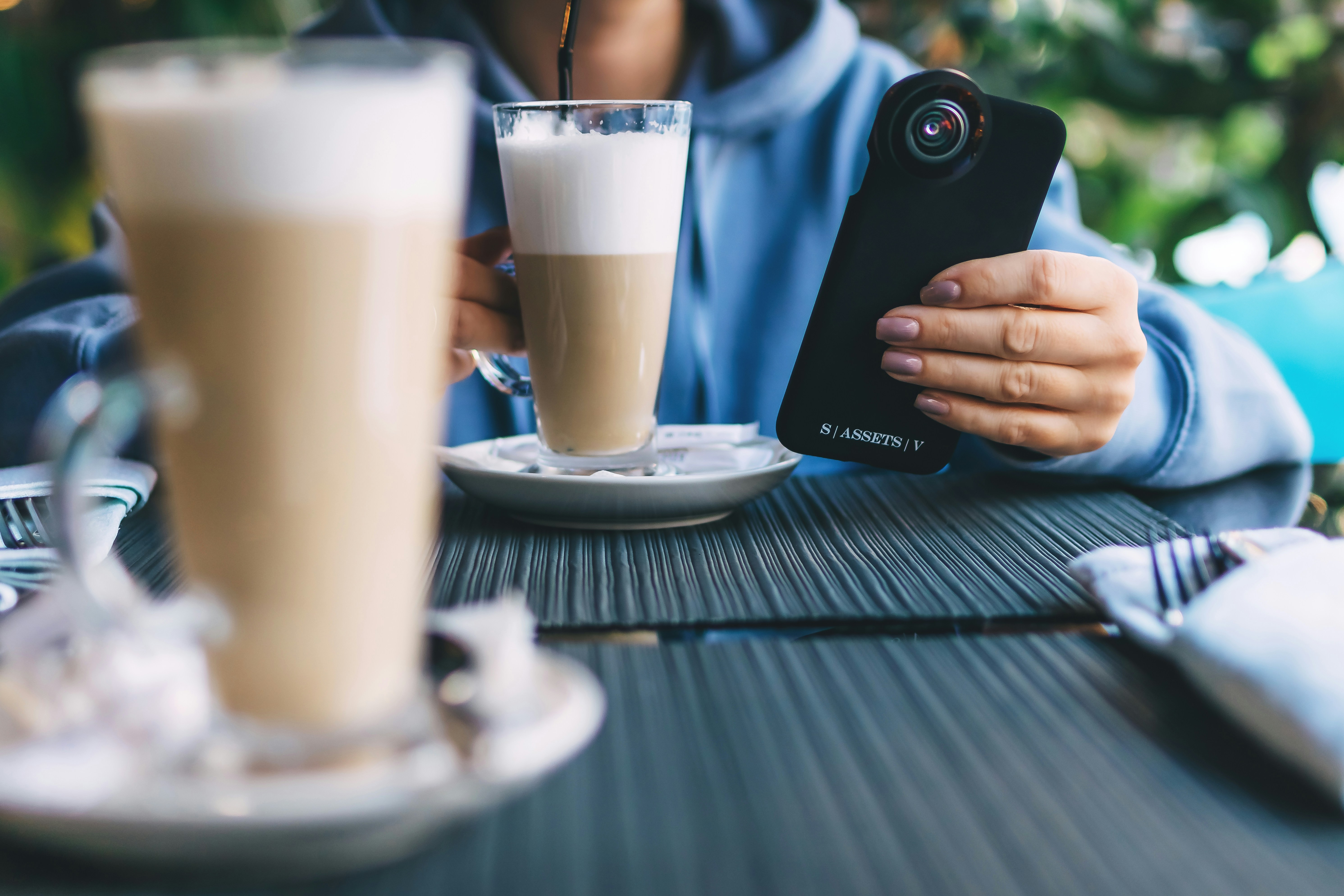 Black iphone 5 on white ceramic saucer beside clear drinking glass ...