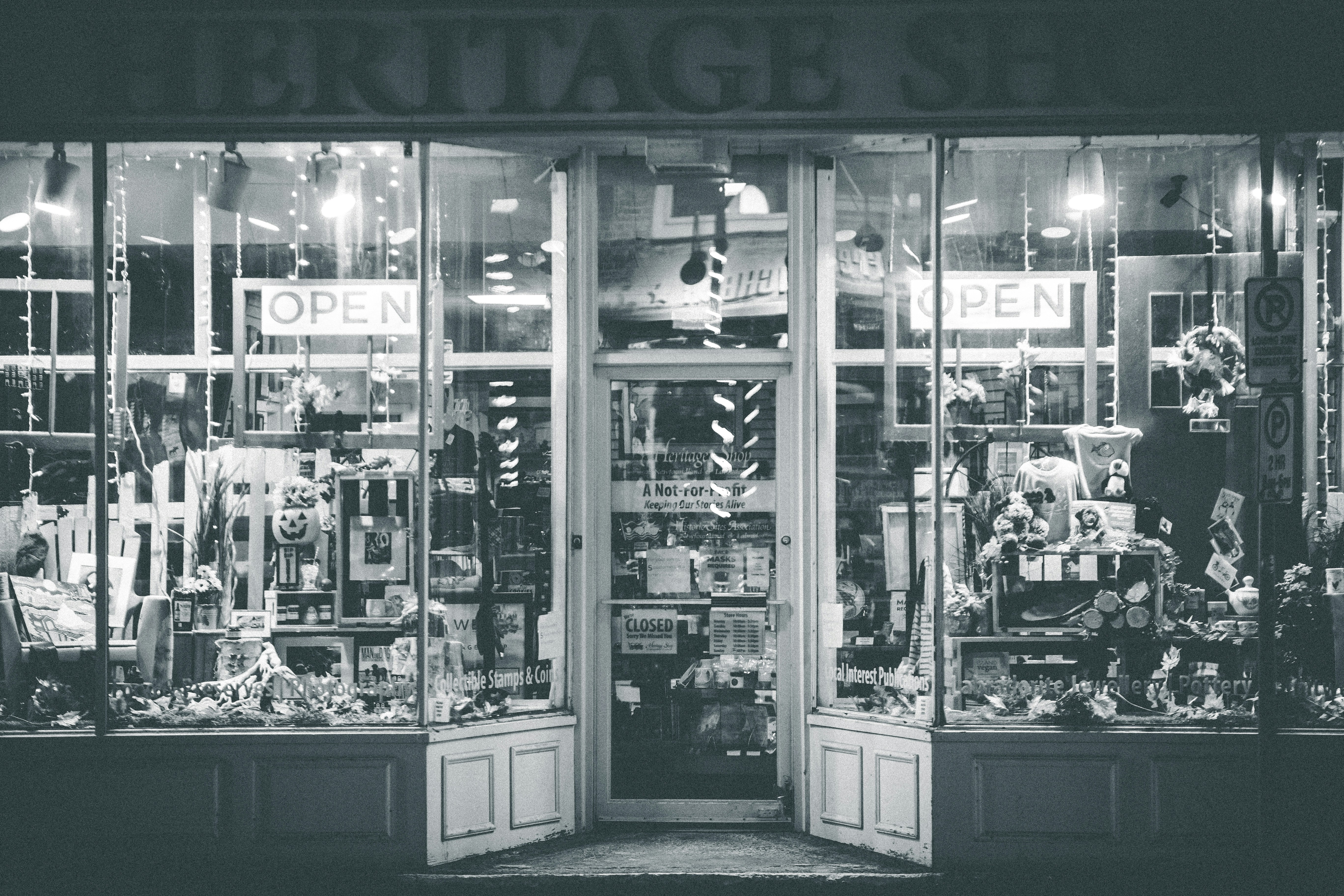 A charming storefront displaying various vintage items and decorations, illuminated by warm lights and an inviting 'OPEN' sign.