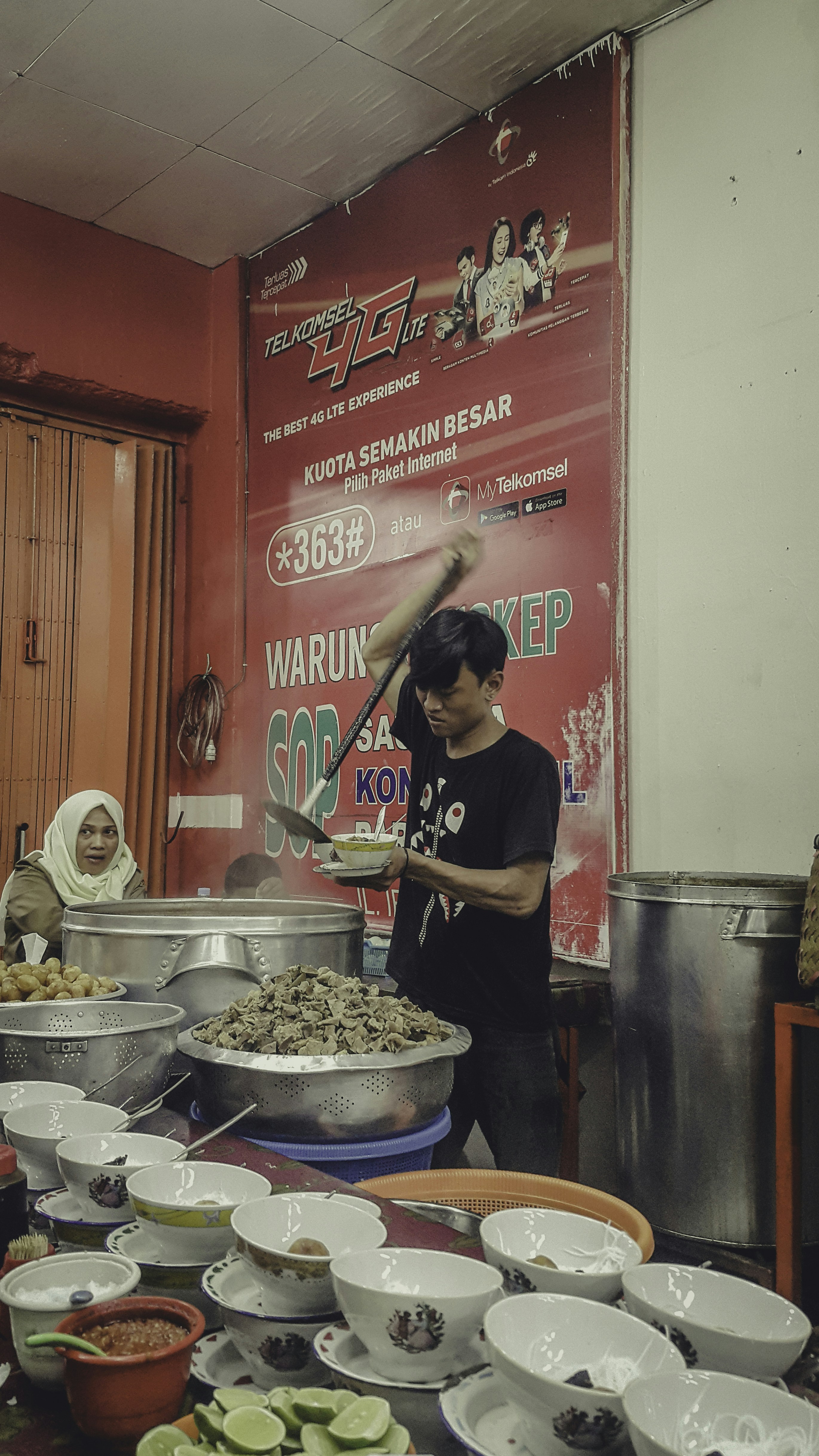 A chef skillfully prepares a traditional dish in a bustling eatery, surrounded by vibrant ingredients and eager patrons. The atmosphere is lively and inviting.