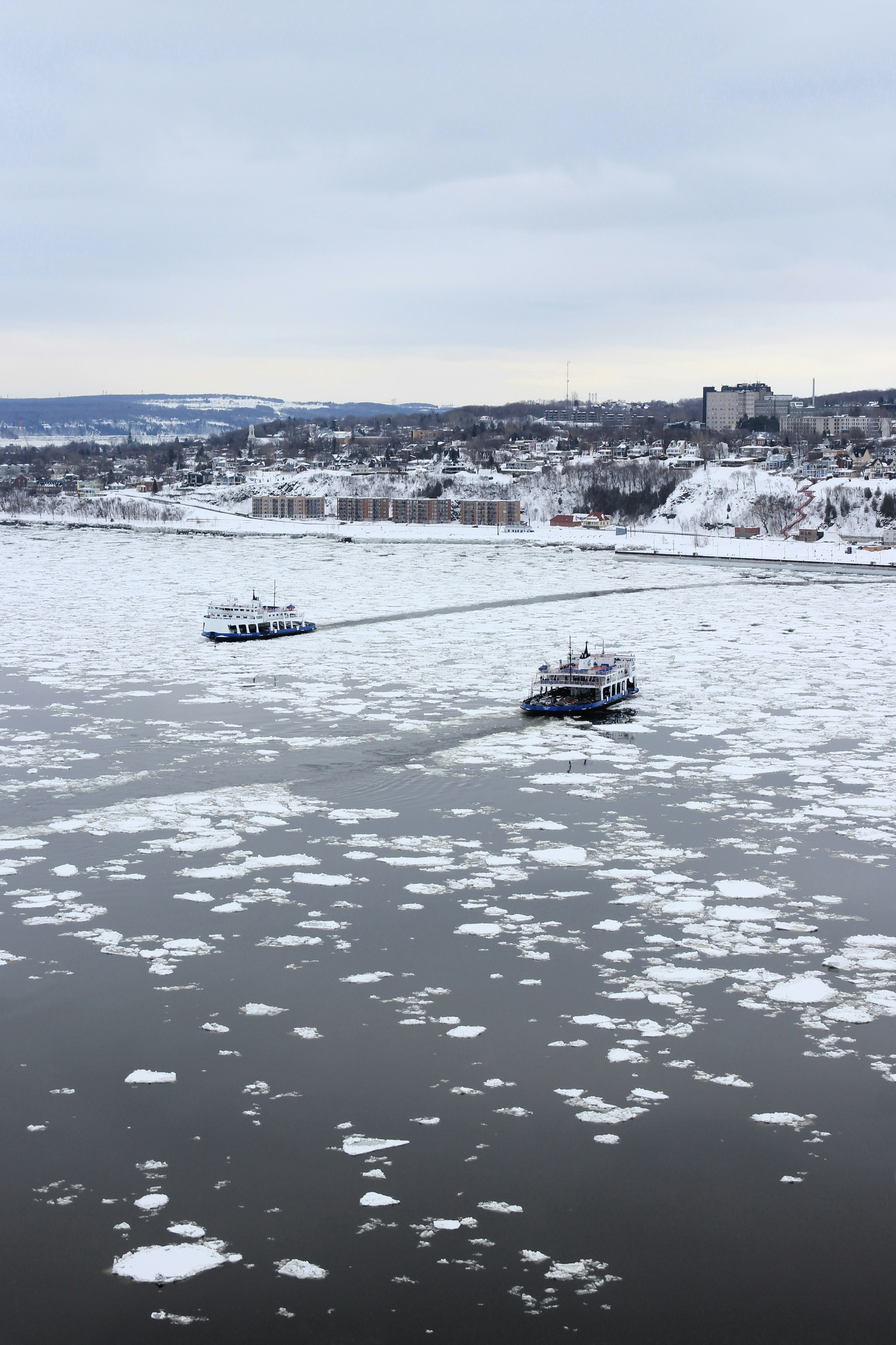 Icebound Crossing: Two Boats Thread a Patchwork River Under Snow