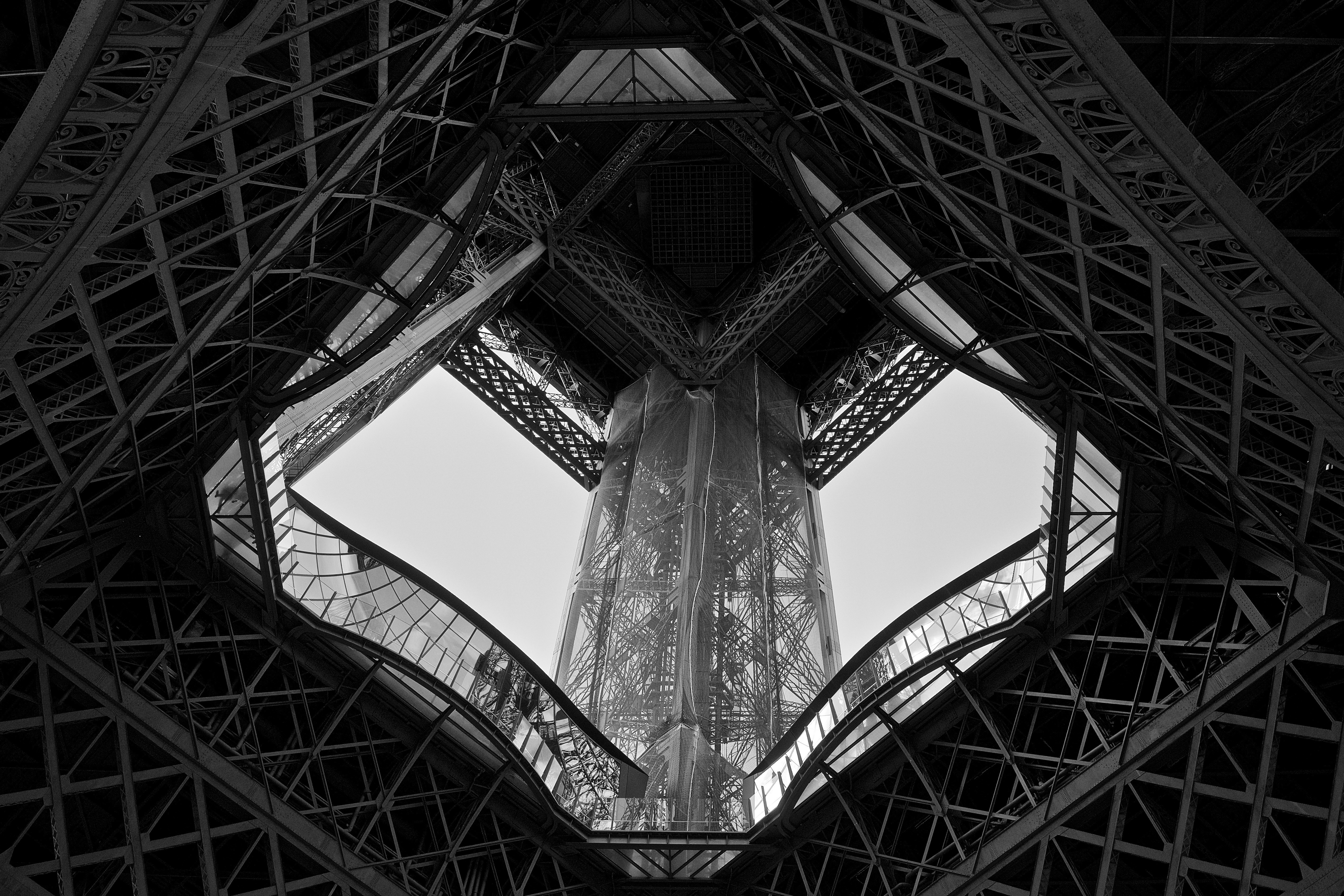 Vertical Lattice: Centered Iron Spine Rising Through a Web of Arches
