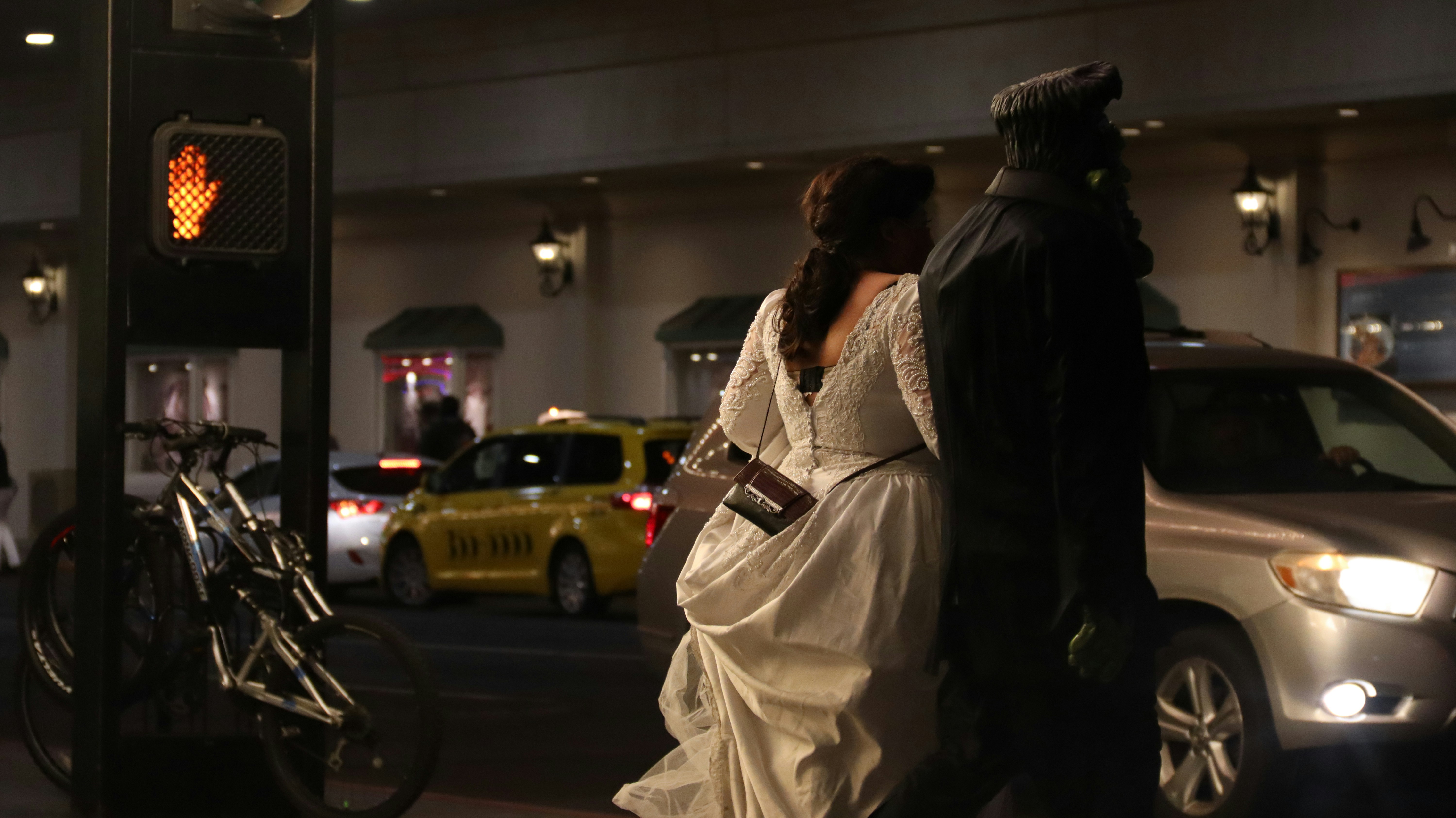 Woman in white and black coat standing beside black car during night ...
