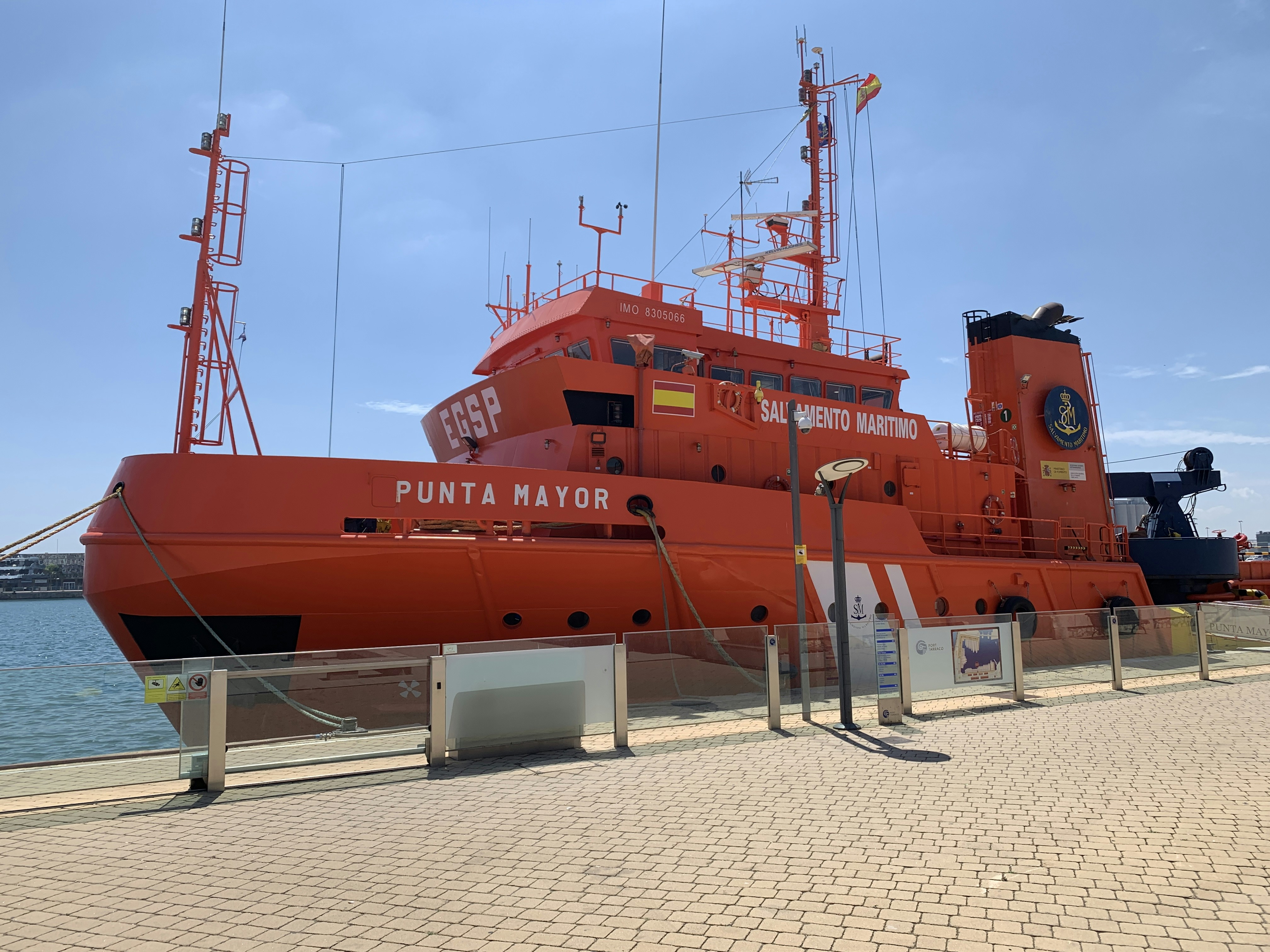 Punta Mayor at Full Red: A Rescue Vessel Framed by a Sunny Harbor Promenade