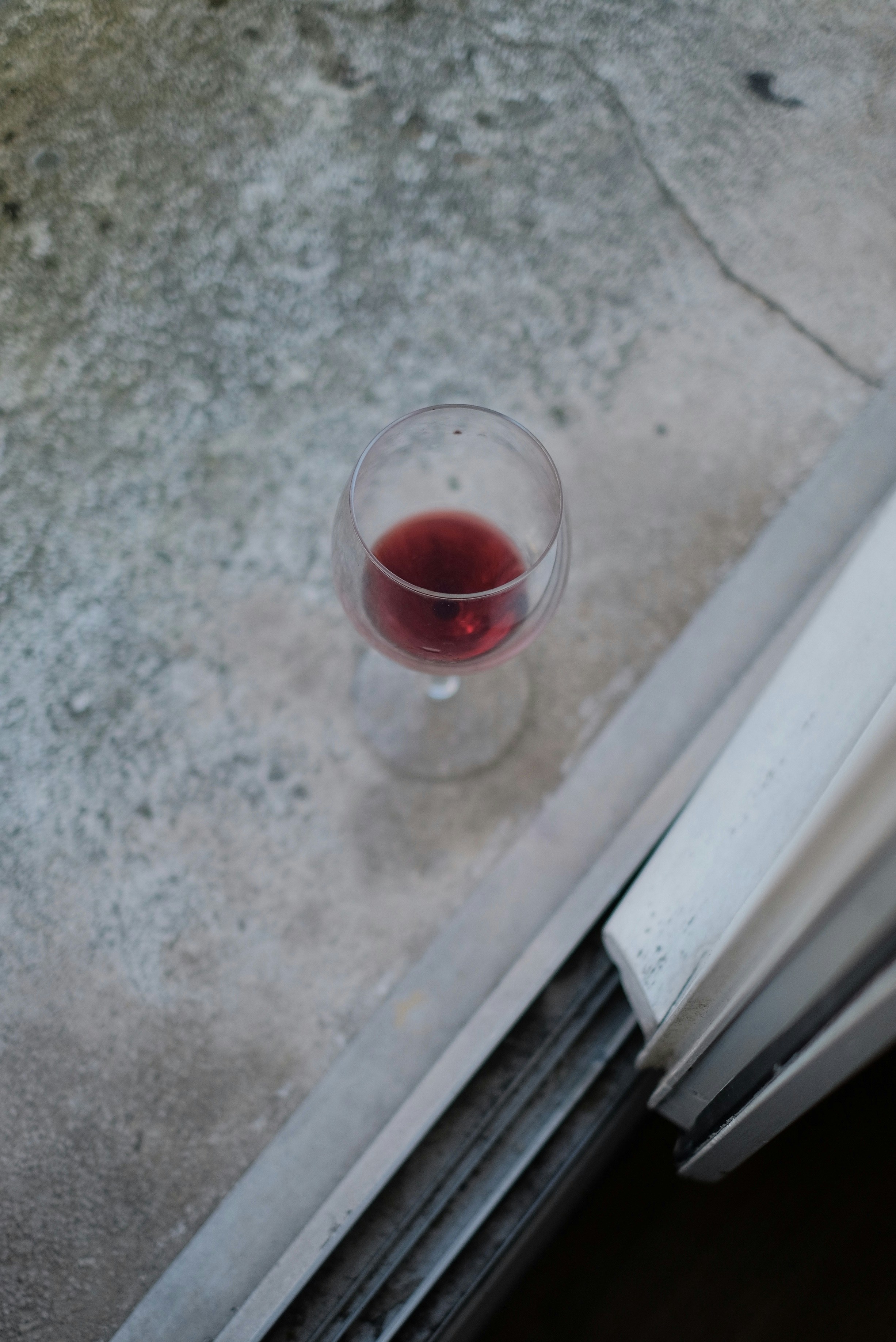 Crimson Glass at the Threshold: Red Wine on Concrete