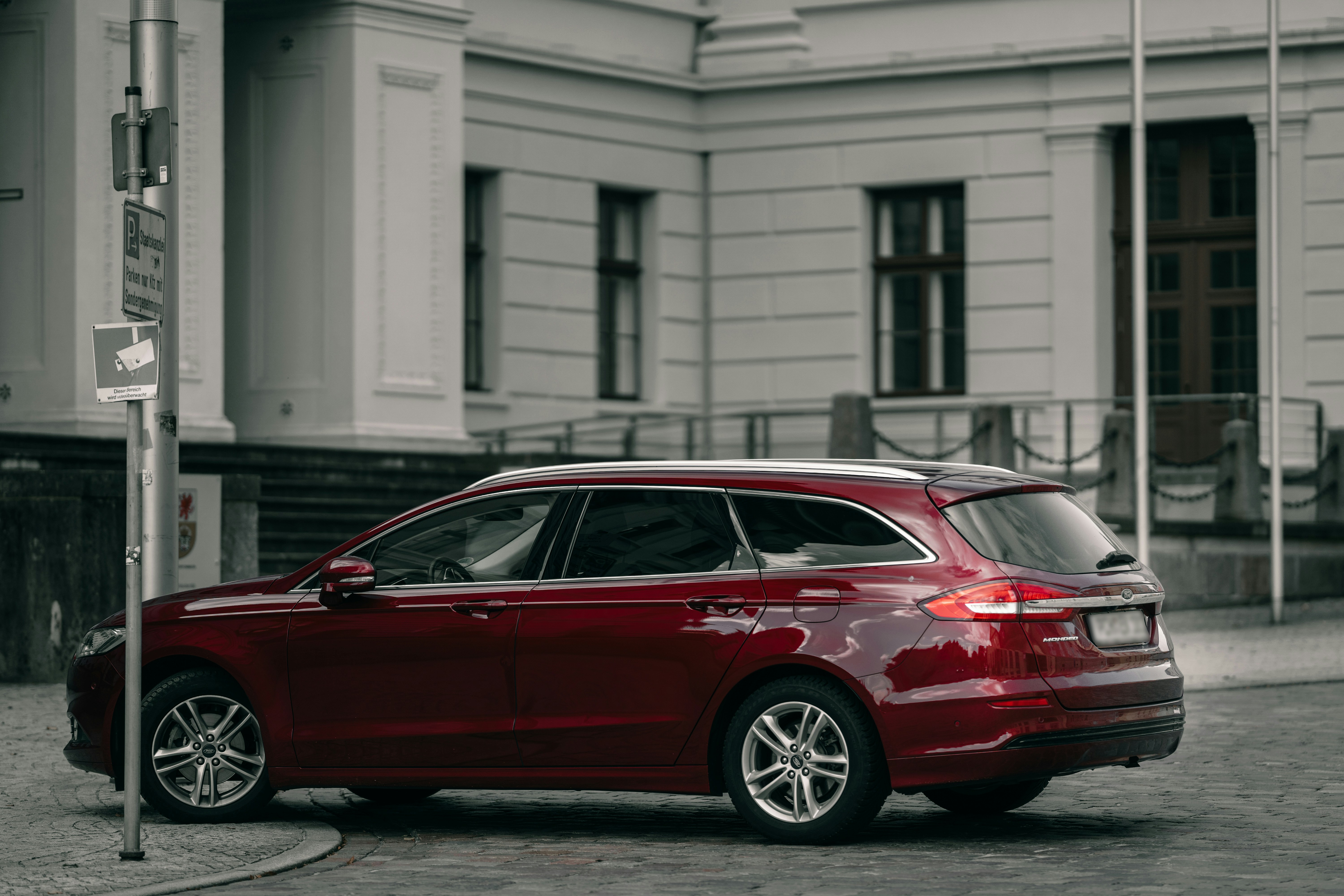 Red station wagon parked near white building during daytime photo ...
