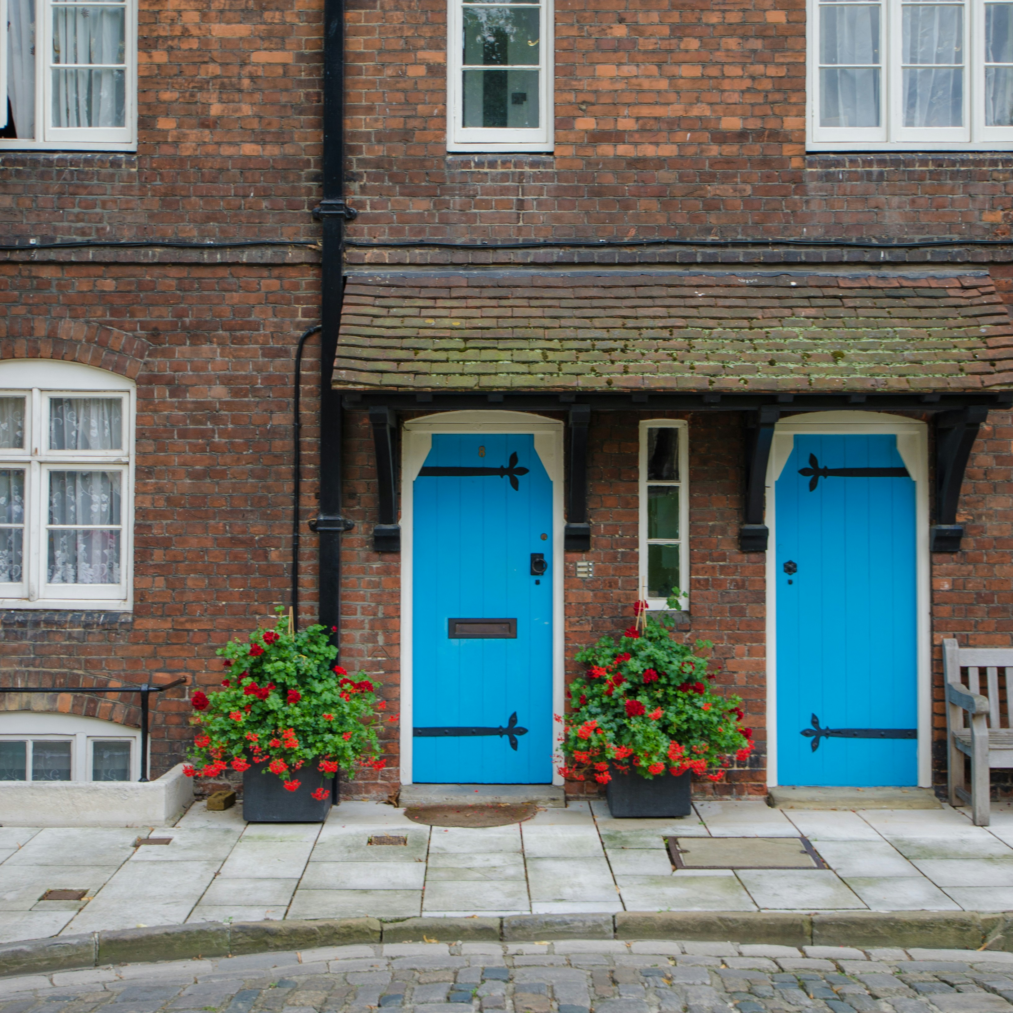 Azure Double Doors: Bright Hues and Quiet Charm Along a Brick Facade