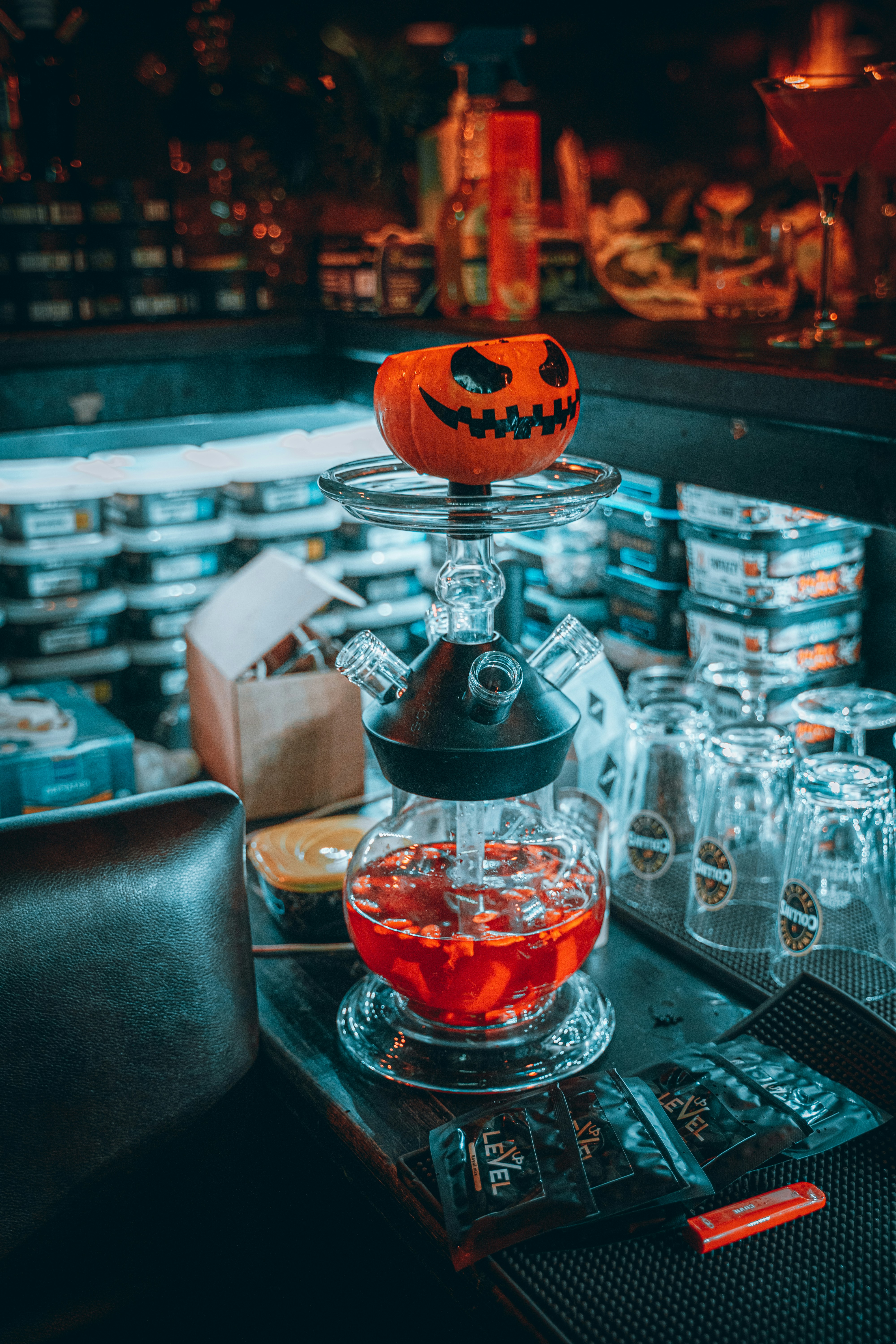 Pumpkin Crowned on a Glass Hookah: Neon Halloween Bar Scene