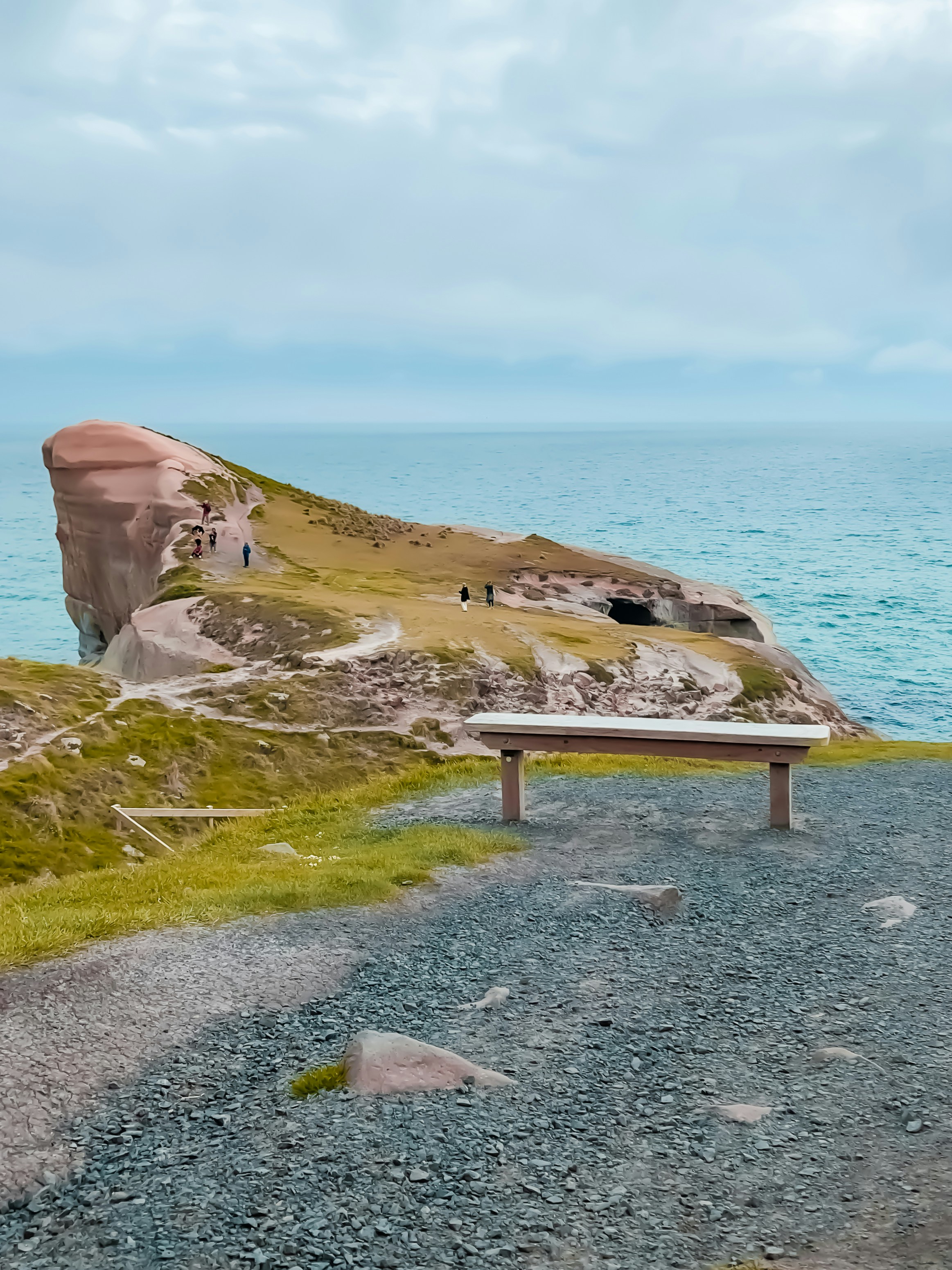brown wooden table on gray sand near body of water during daytime