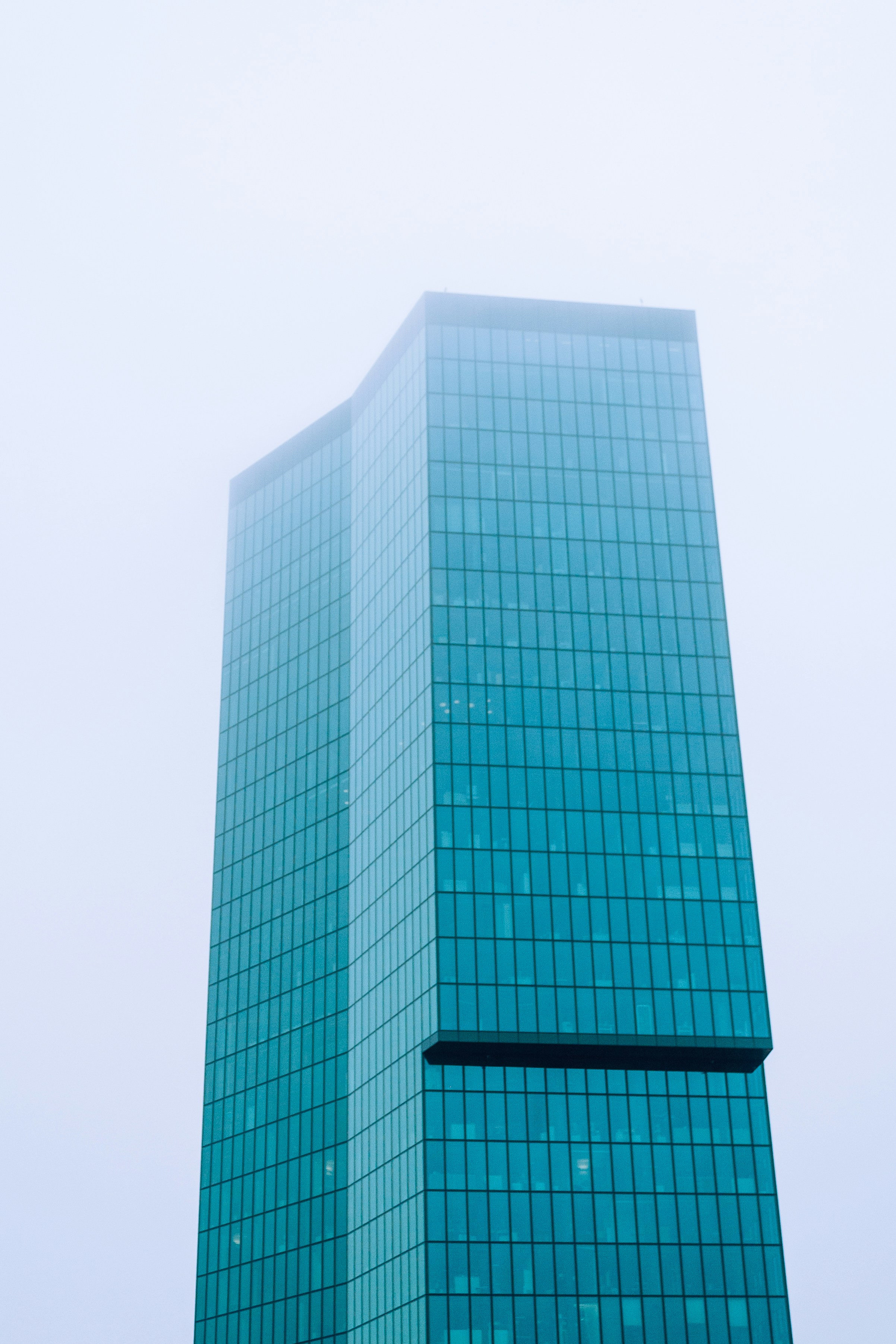 Azure Glass Tower Rising Through Pale Fog