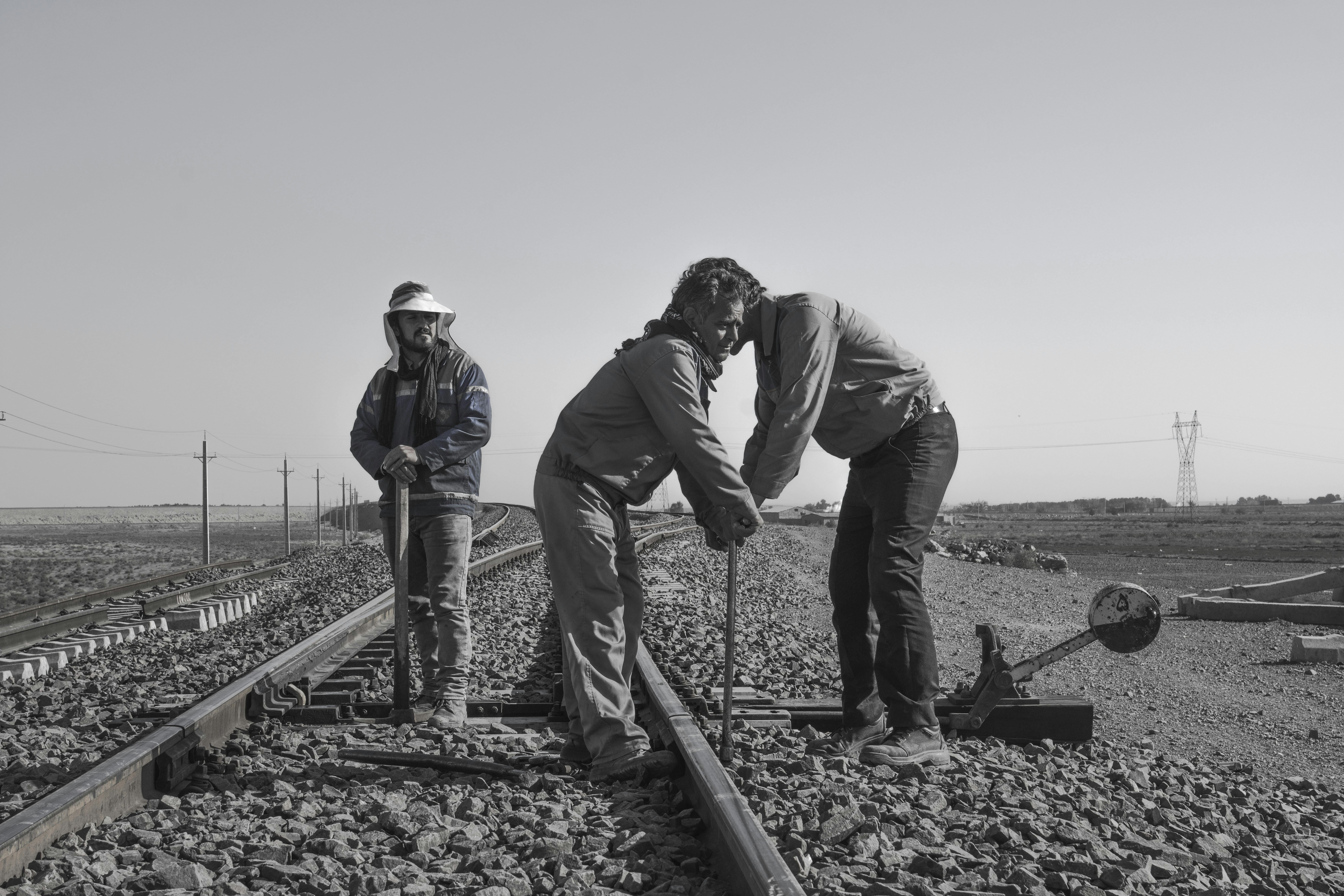 Man in gray jacket and blue denim jeans standing on train rail during ...
