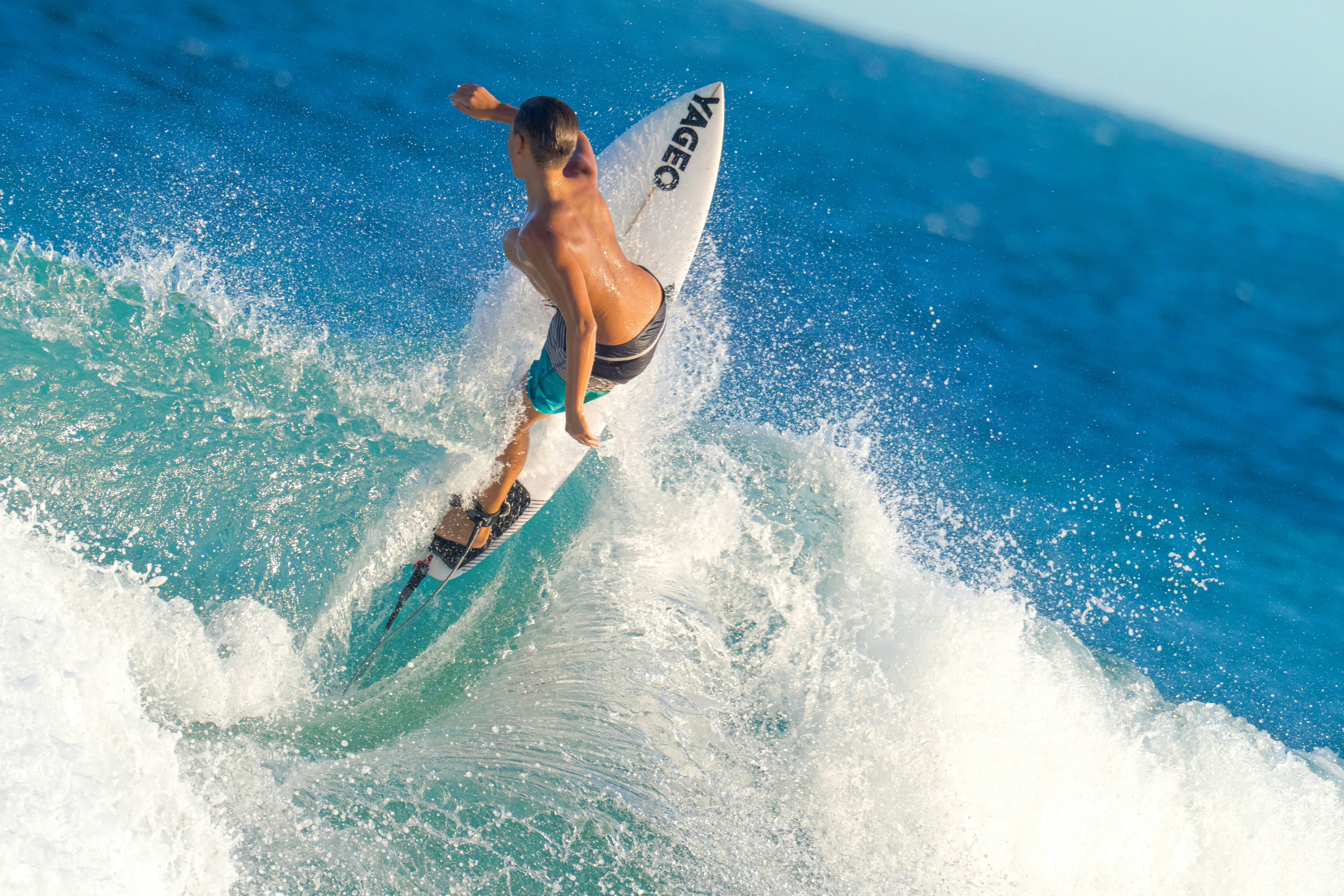 Man in blue shorts surfing on sea waves during daytime photo – Free ...