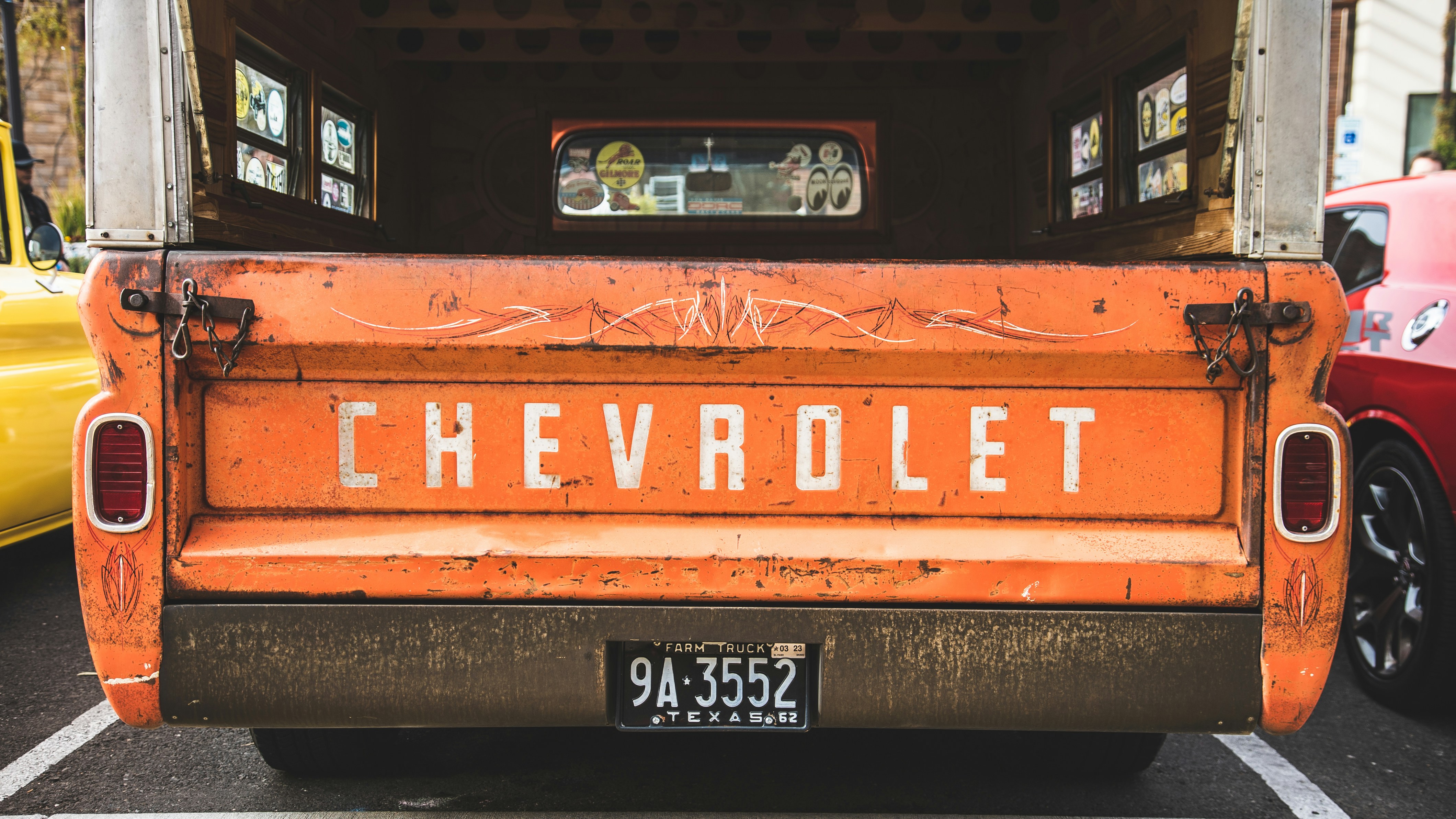 Rusty Orange Chevrolet Tailgate: A Timeworn Icon Resting in a Parking Lot