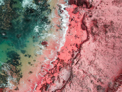 Crimson Coastlines: Aerial Confluence of Turquoise, Peach, and Red Sands
