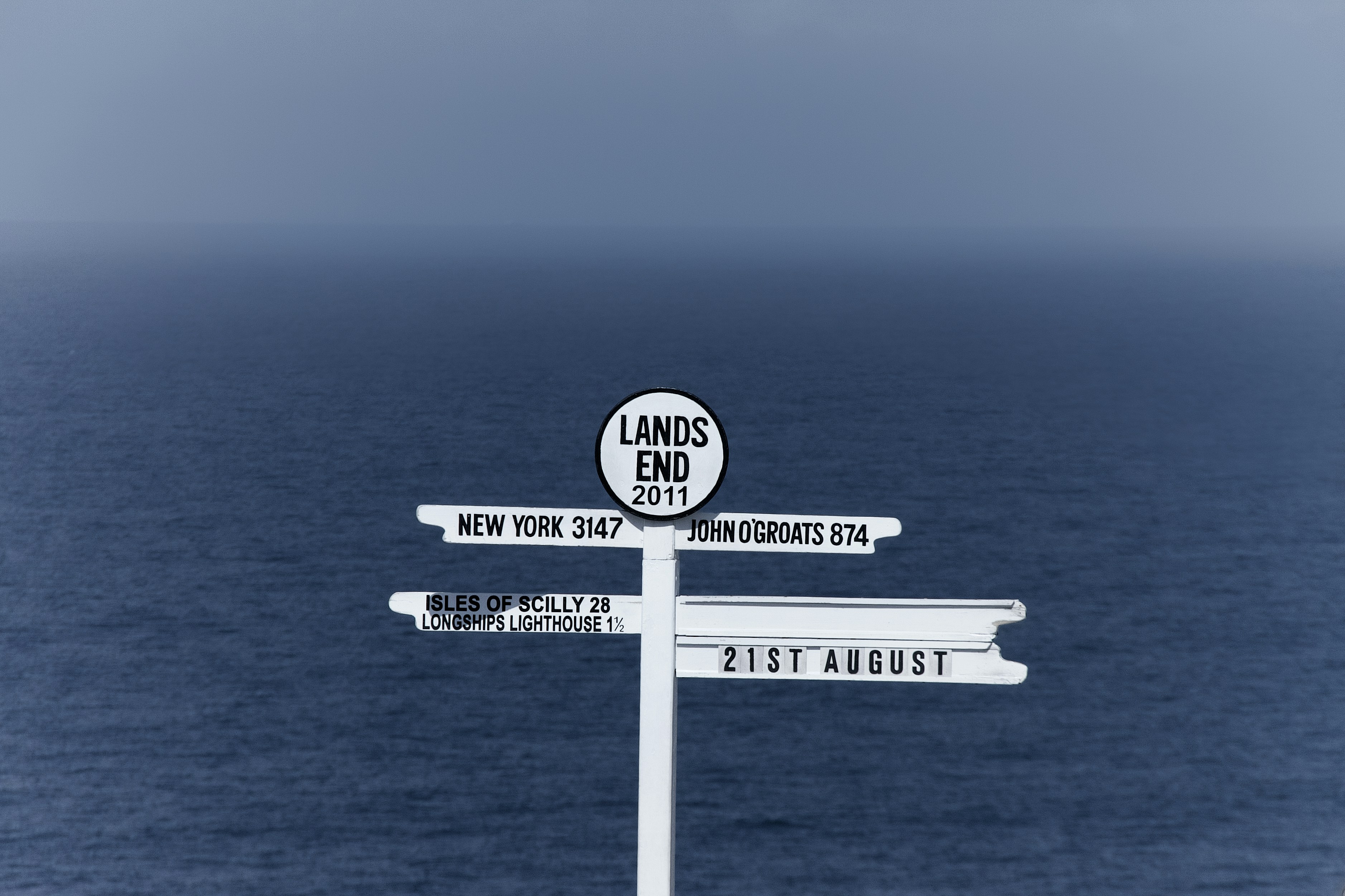 Lands End Signpost Over the Atlantic: A Lone Marker in a Sea of Blue