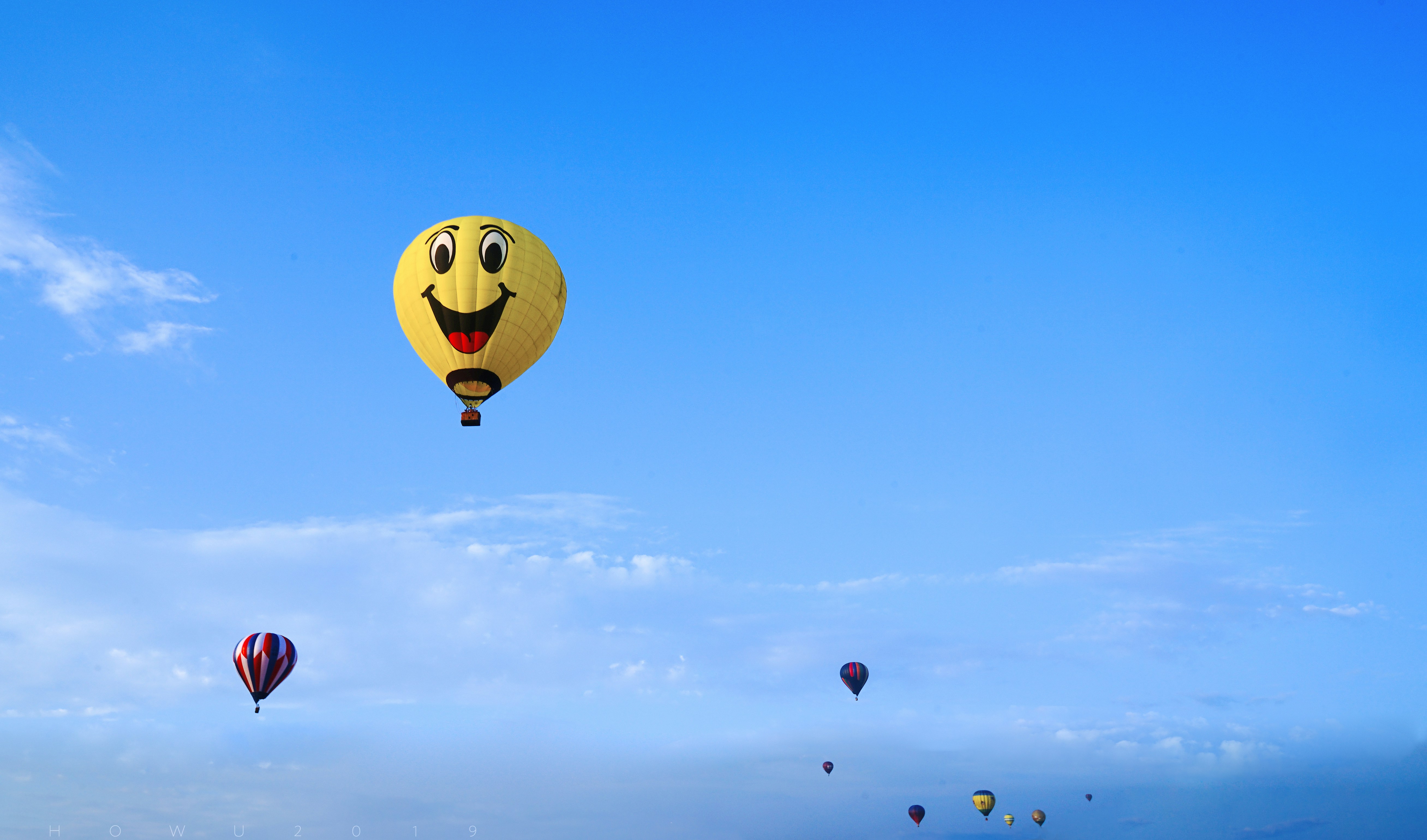 Yellow and red hot air balloon in mid air under blue sky during daytime ...
