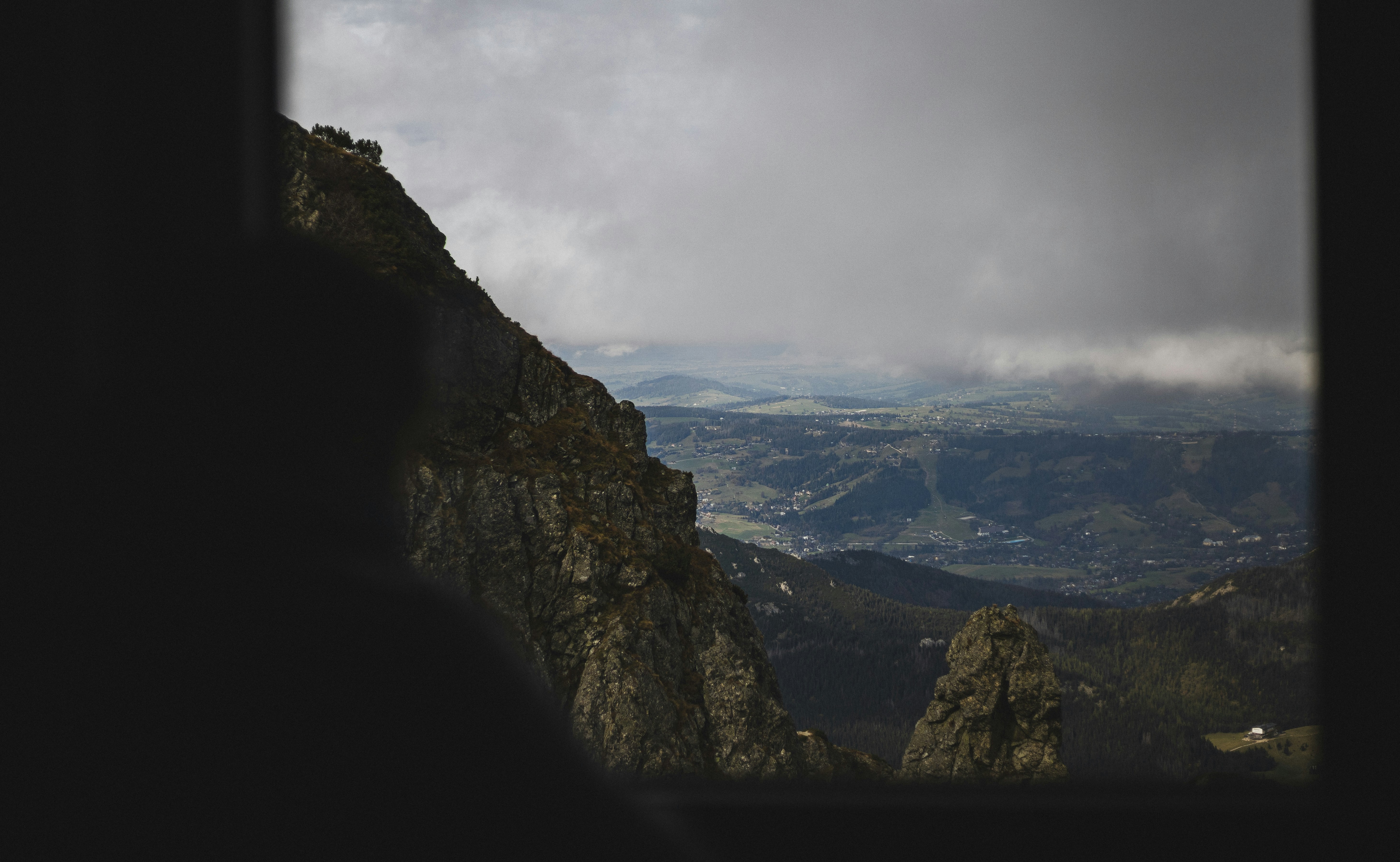 Silhouette of a figure gazing out at a dramatic mountain landscape shrouded in mist, capturing a moment of reflection and connection with nature.