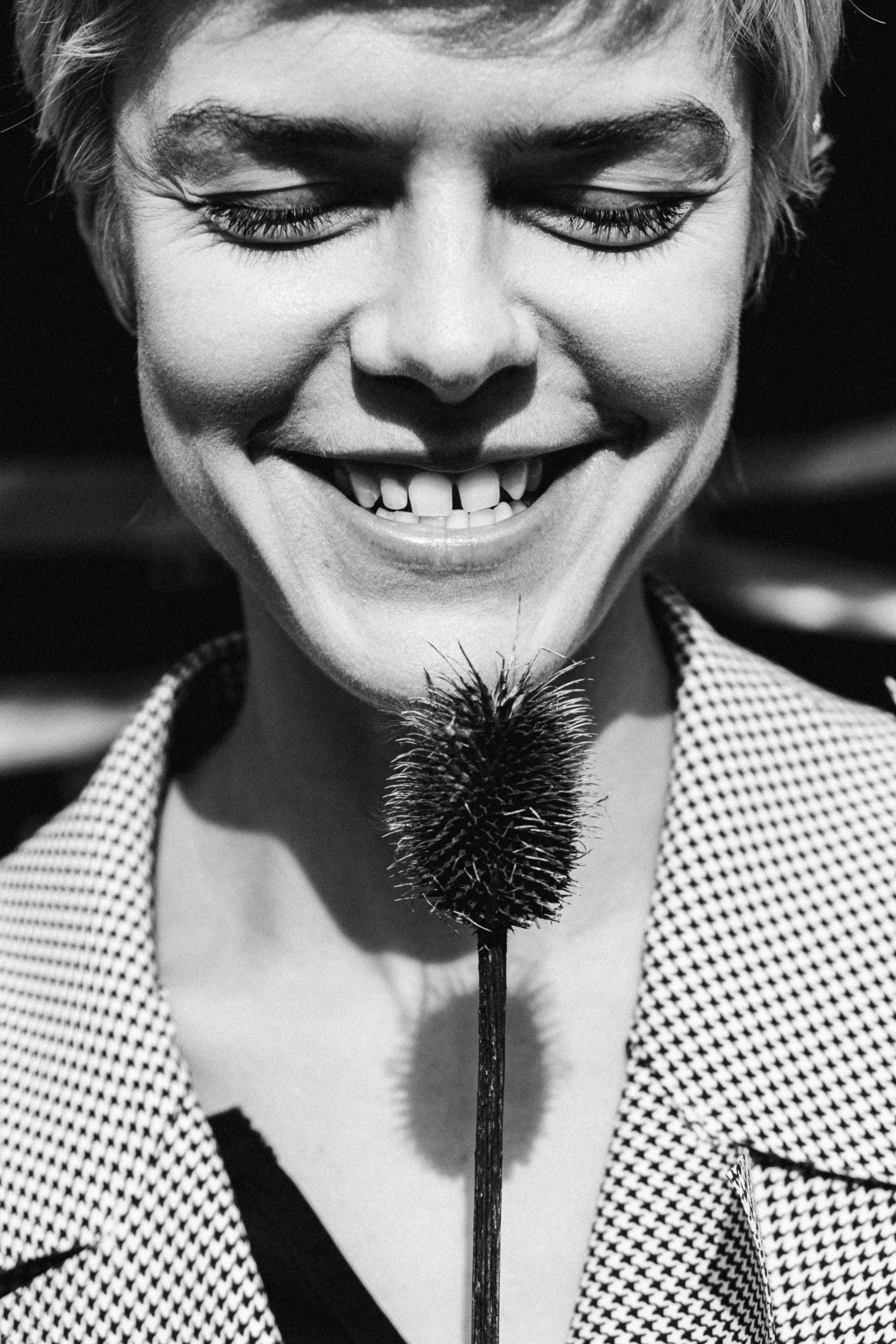 grayscale photo of woman with flower on her ear