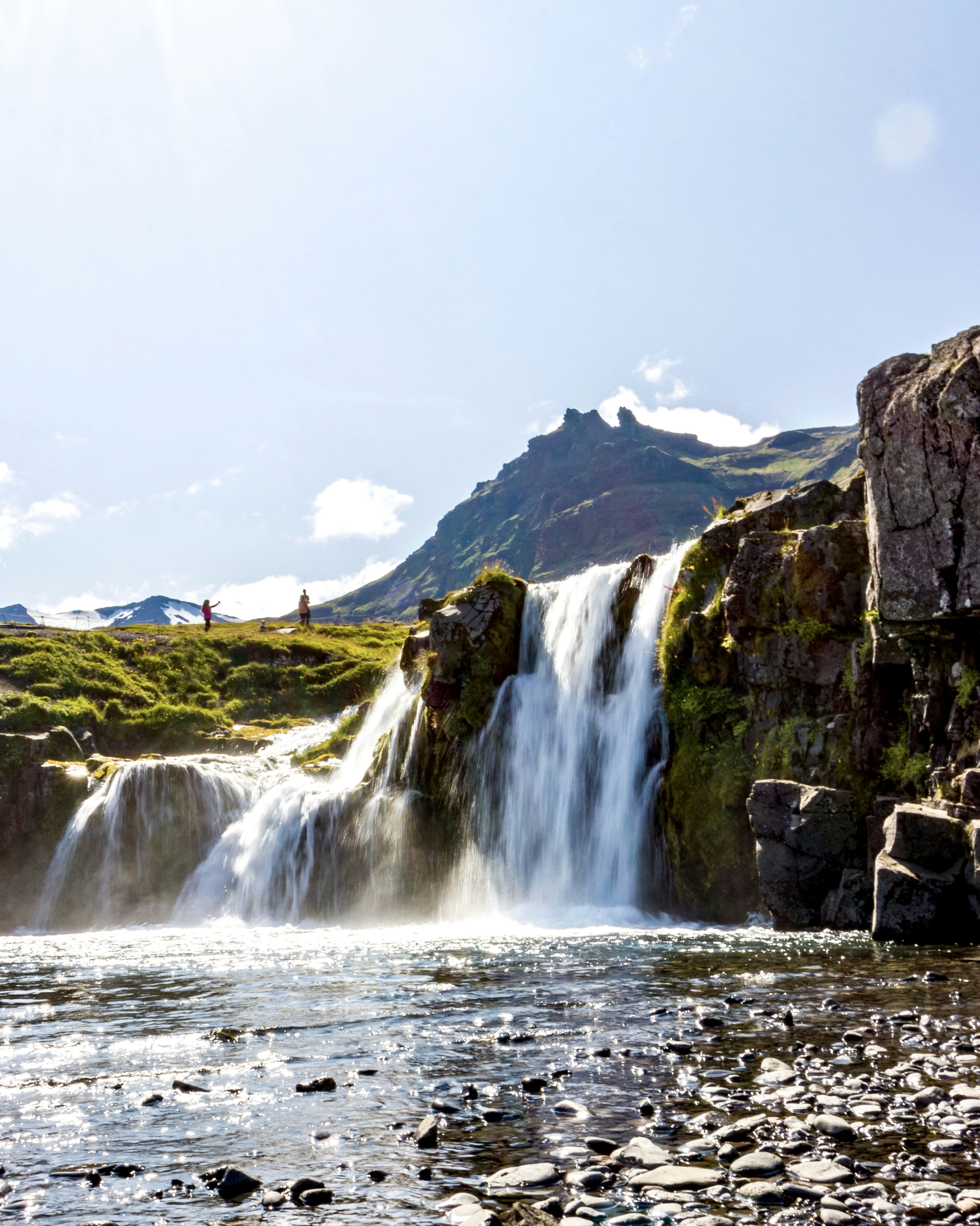 Moss-Crowned Cascade at a Sunlit Alpine Overlook