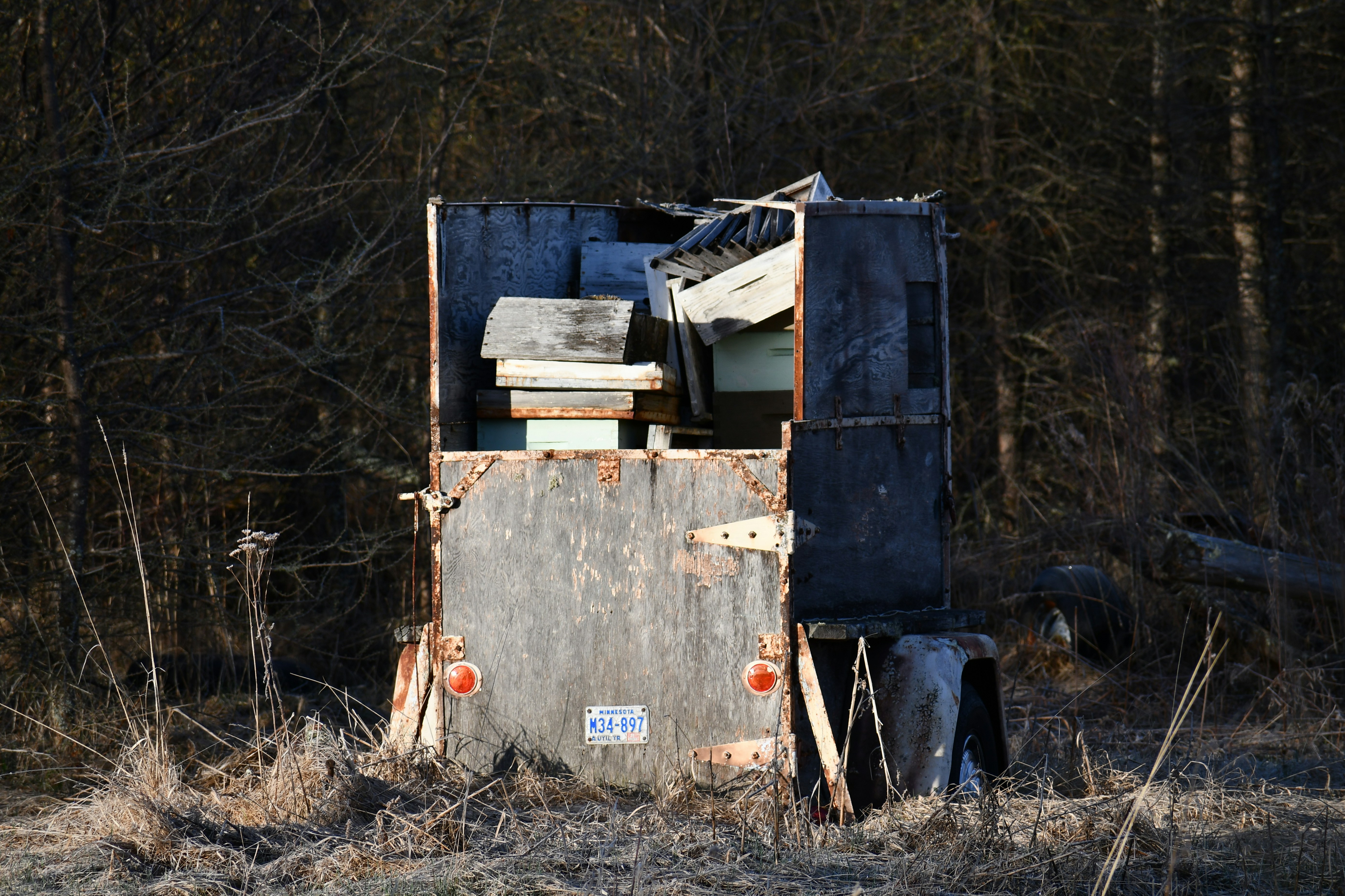 An old trailer full of wooden beehives on the farm.