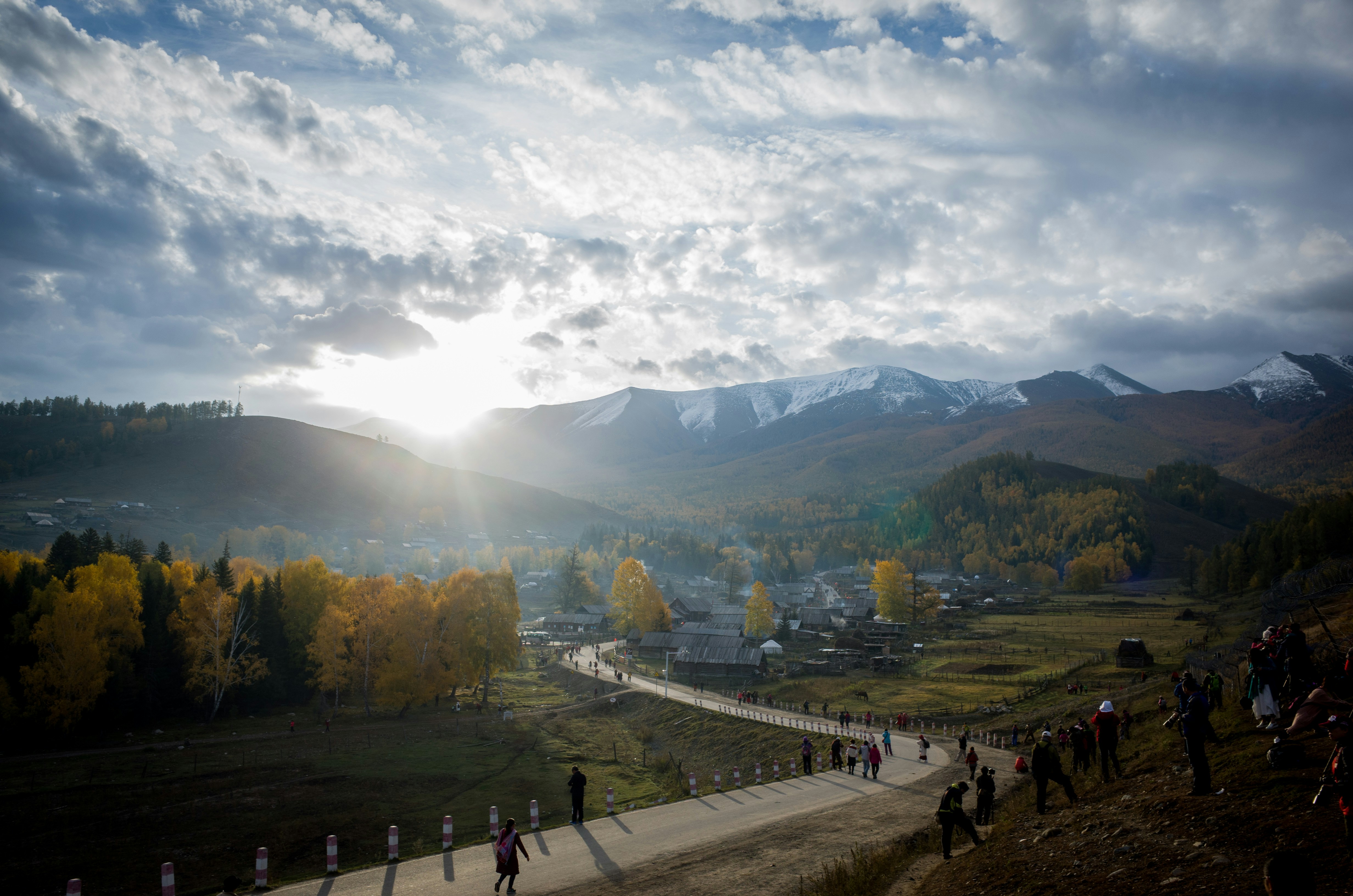 People walking on road near green trees and mountains during daytime ...