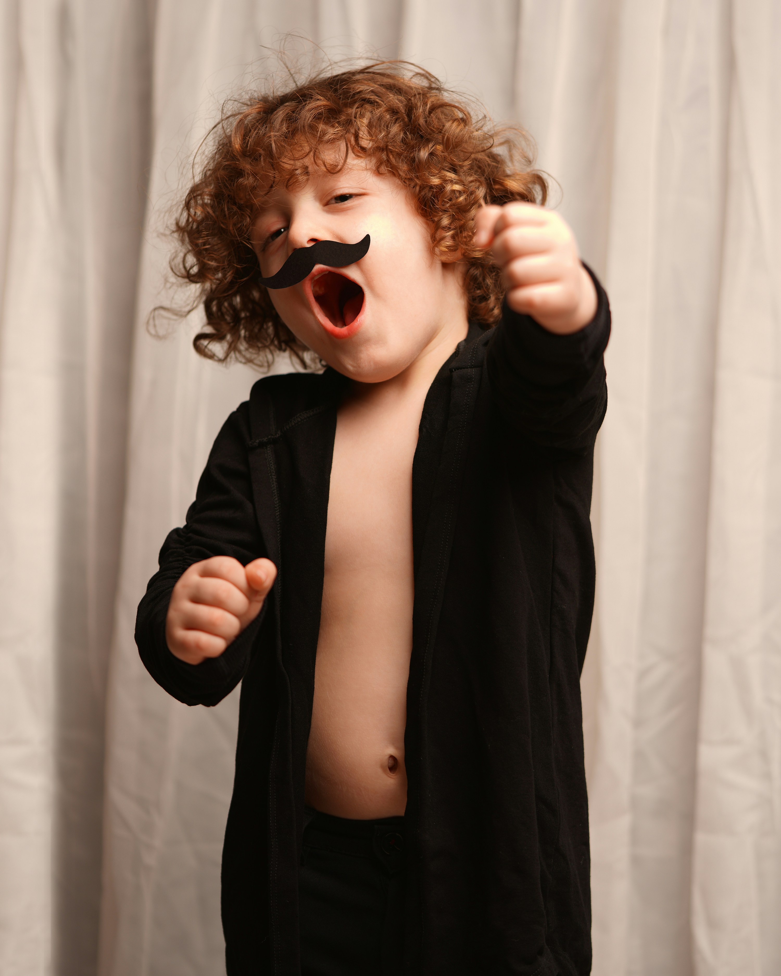 Tiny Showman: Curls, Mask, and a Moment in Front of the Curtain