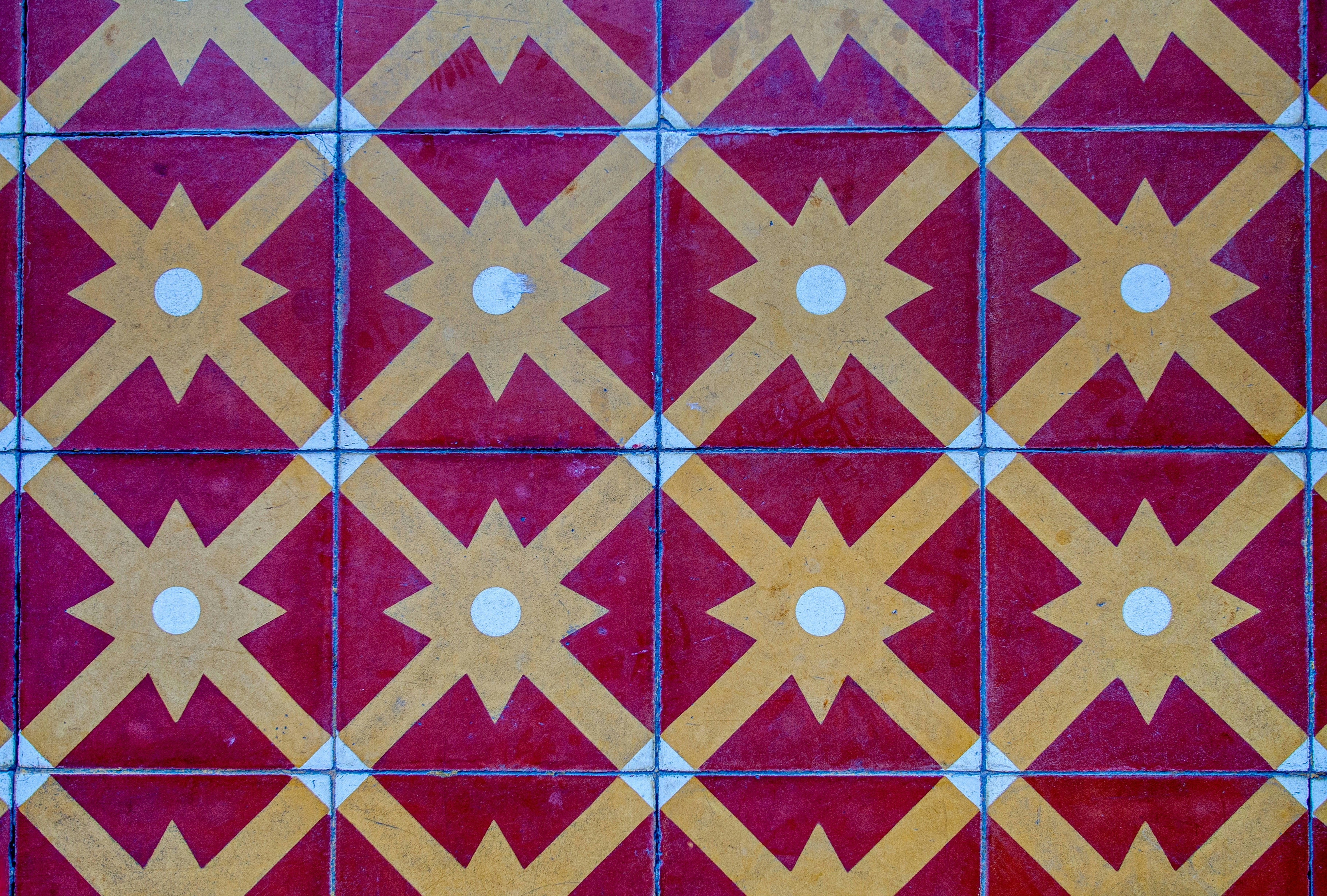 Vibrant tile pattern featuring red and yellow geometric shapes with white accents. A striking design that enhances any space.