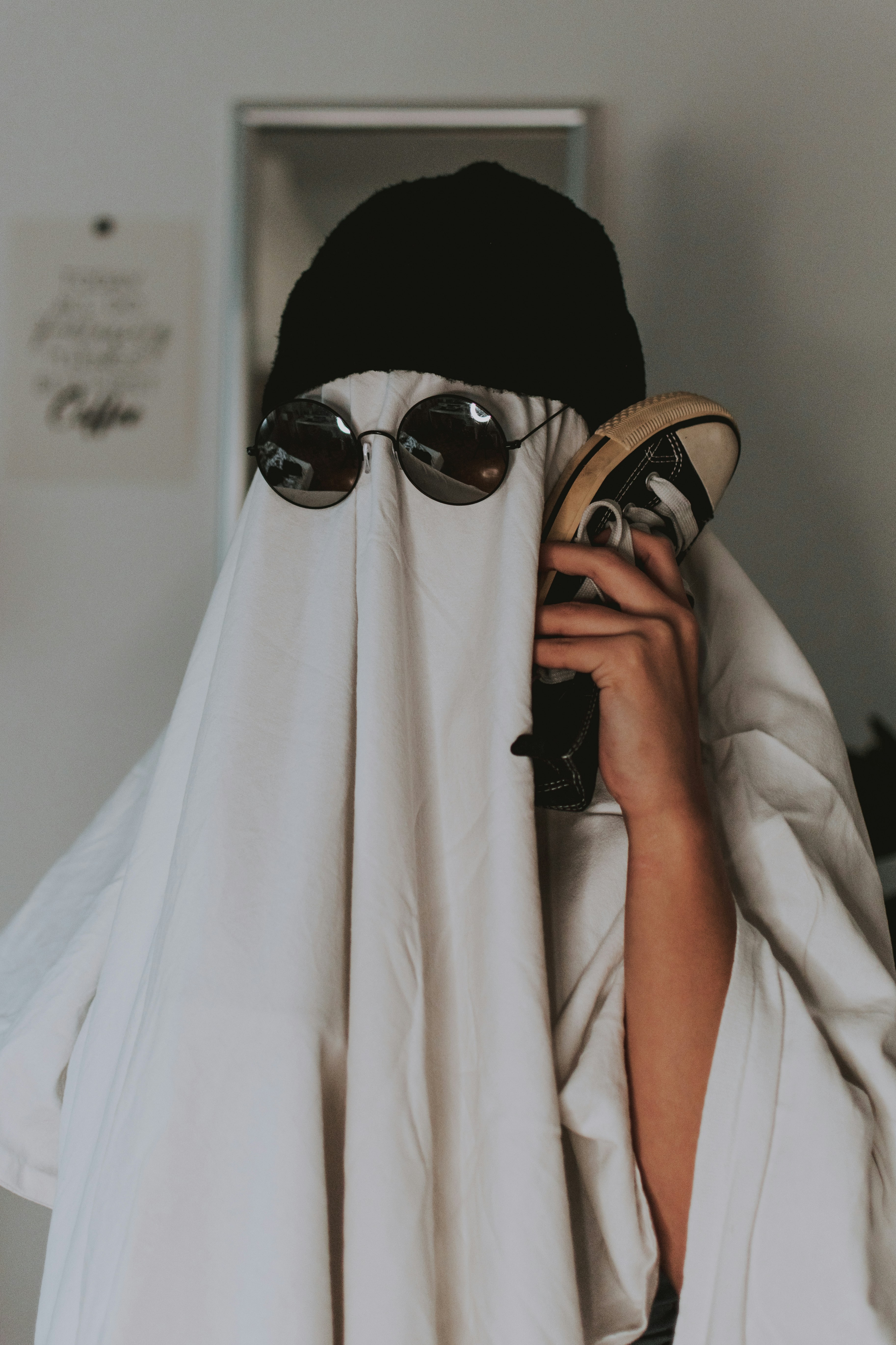 Ghostly Portrait in Sunglasses: A Veiled Figure with a Phone