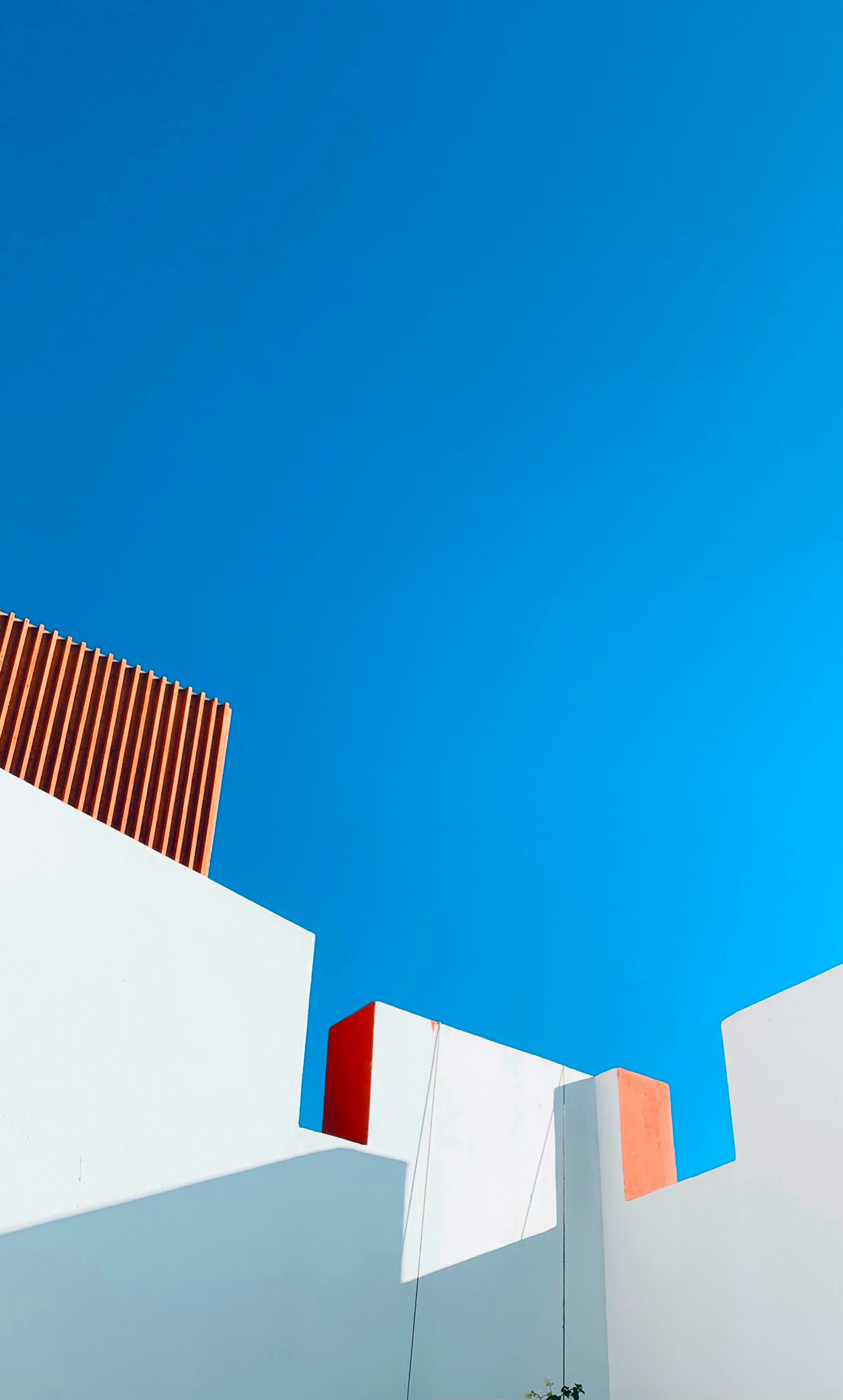 Red Accents on White Geometry Against a Cerulean Sky