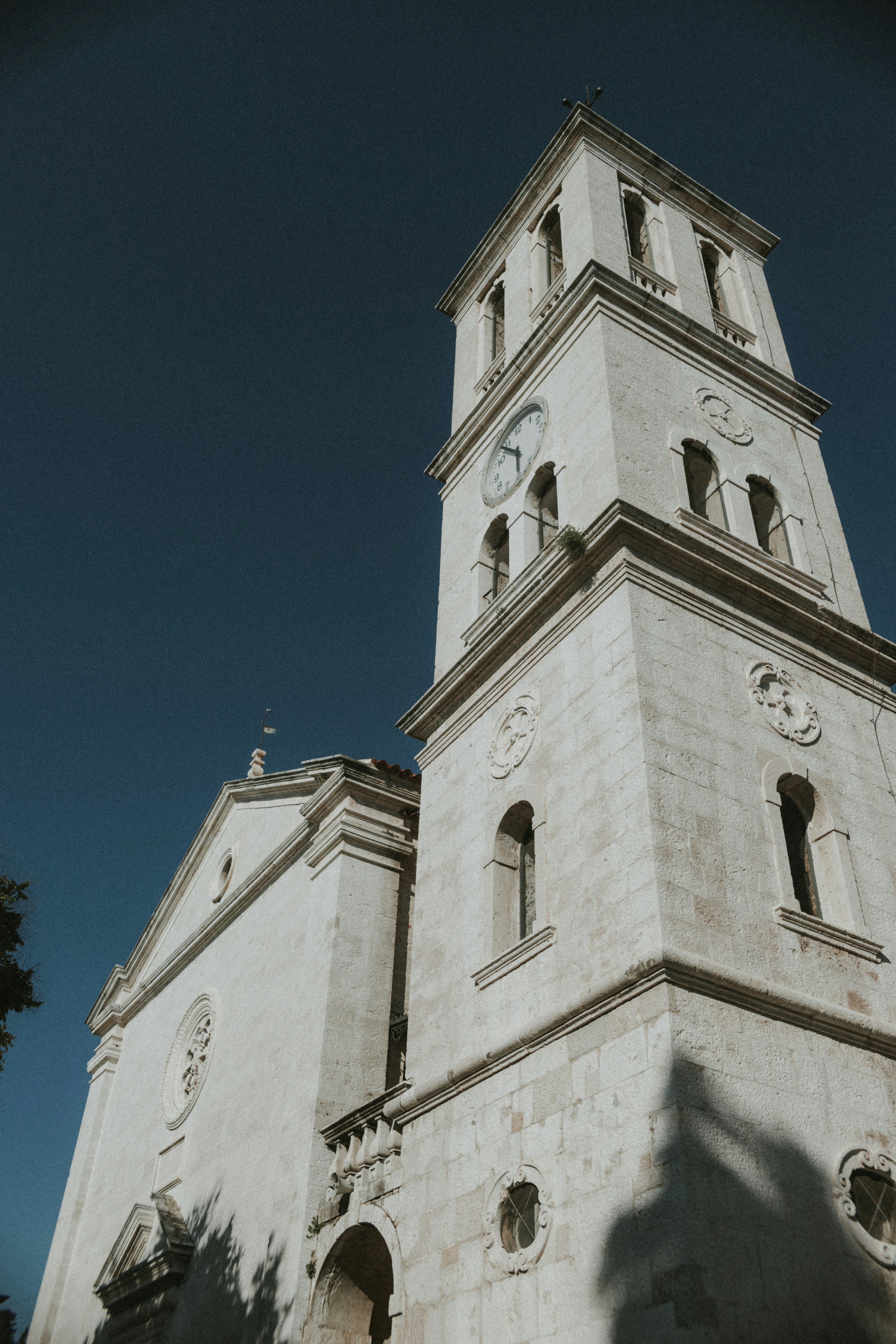 Historic church tower reaching skyward, showcasing intricate architectural details against a clear blue sky.