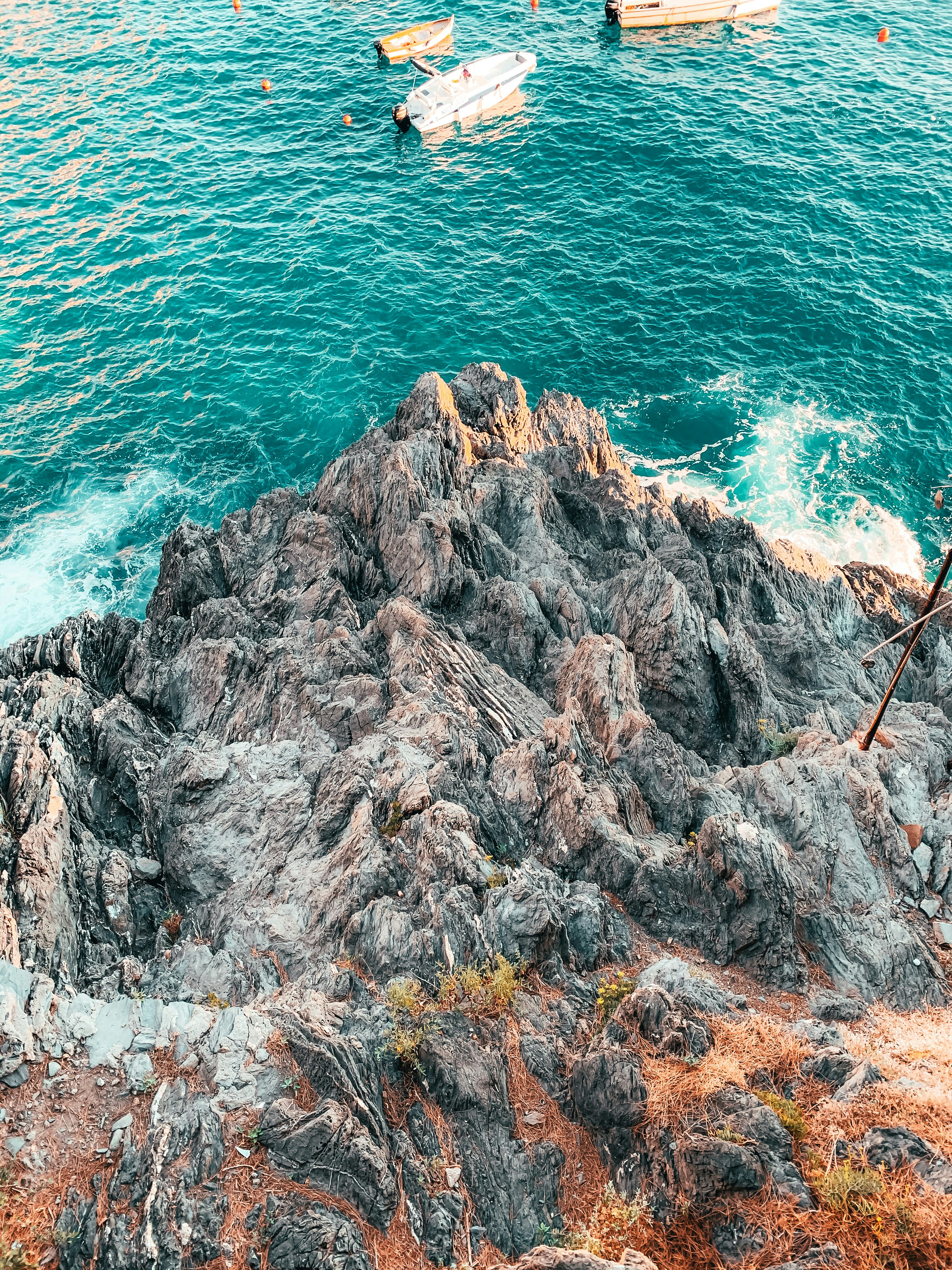 brown rock formation beside body of water during daytime