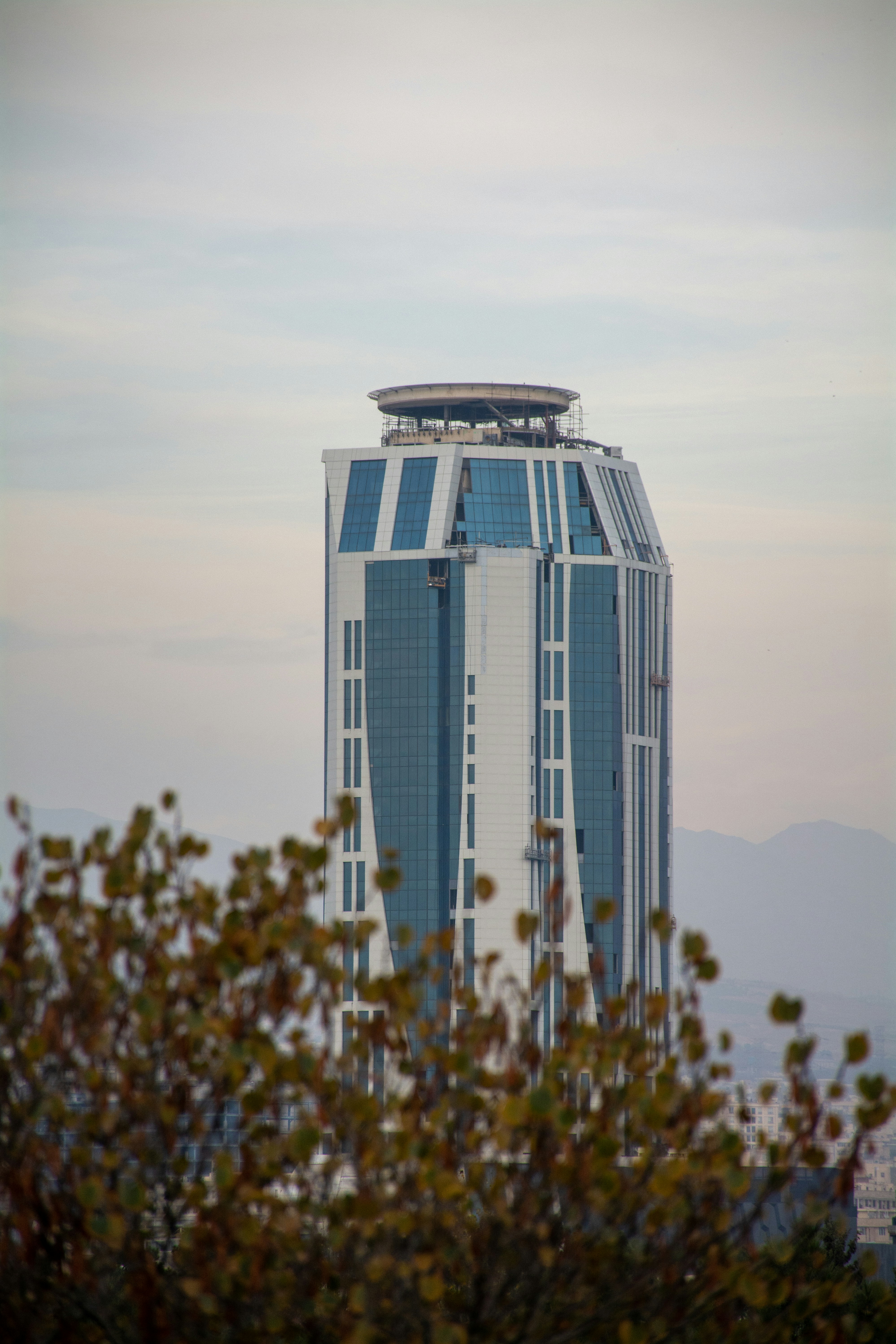 Cobalt Skyline: The Crowned High-Rise Emerging Through Spring Mists